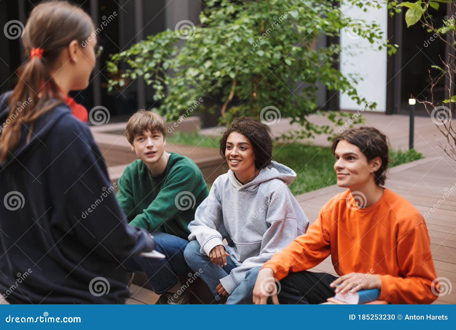 Group of Smiling Students Sitting and Happily Spending Time Together in ...