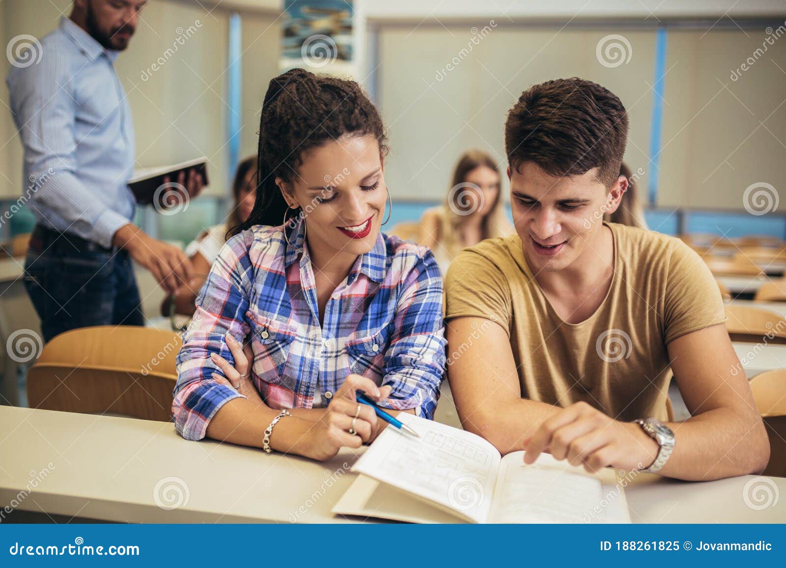 Smiling Students and Teacher with Notebook in Classroom Stock Image ...