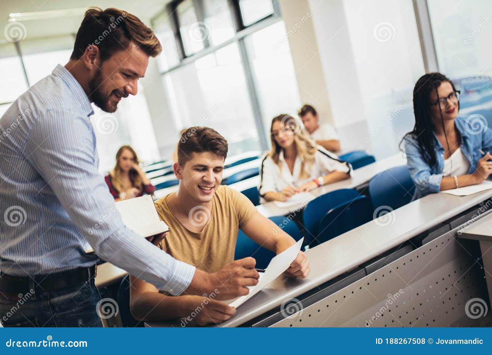 Smiling Students and Teacher with Notebook in Classroom Stock Photo ...