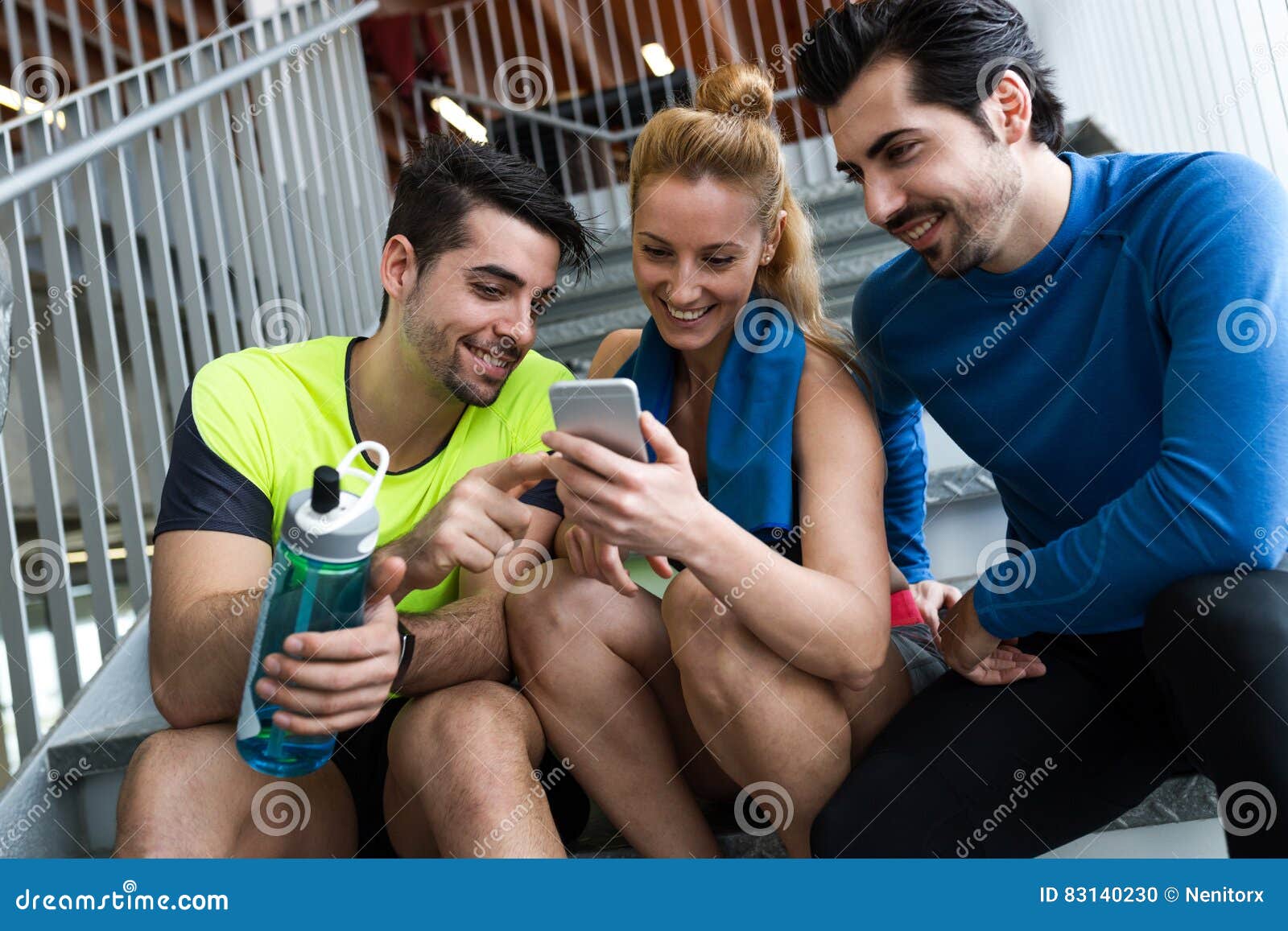 Group of Sporty People Using Mobile Phone in Gym. Stock Photo - Image ...