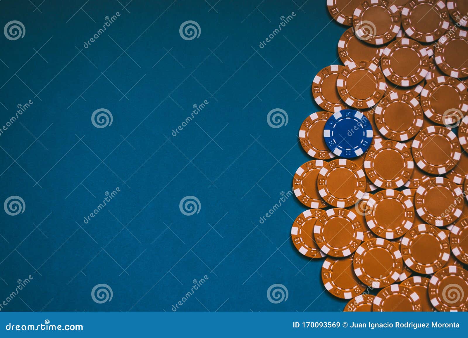Stack of Yellow Poker Chips and a Blue Chip on Top on a Blue Board ...