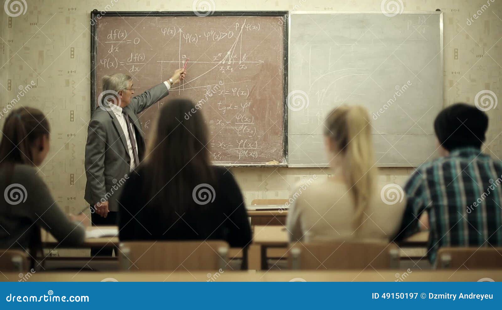Group of Students in a Classroom, Listening As Their Teacher Holds a ...
