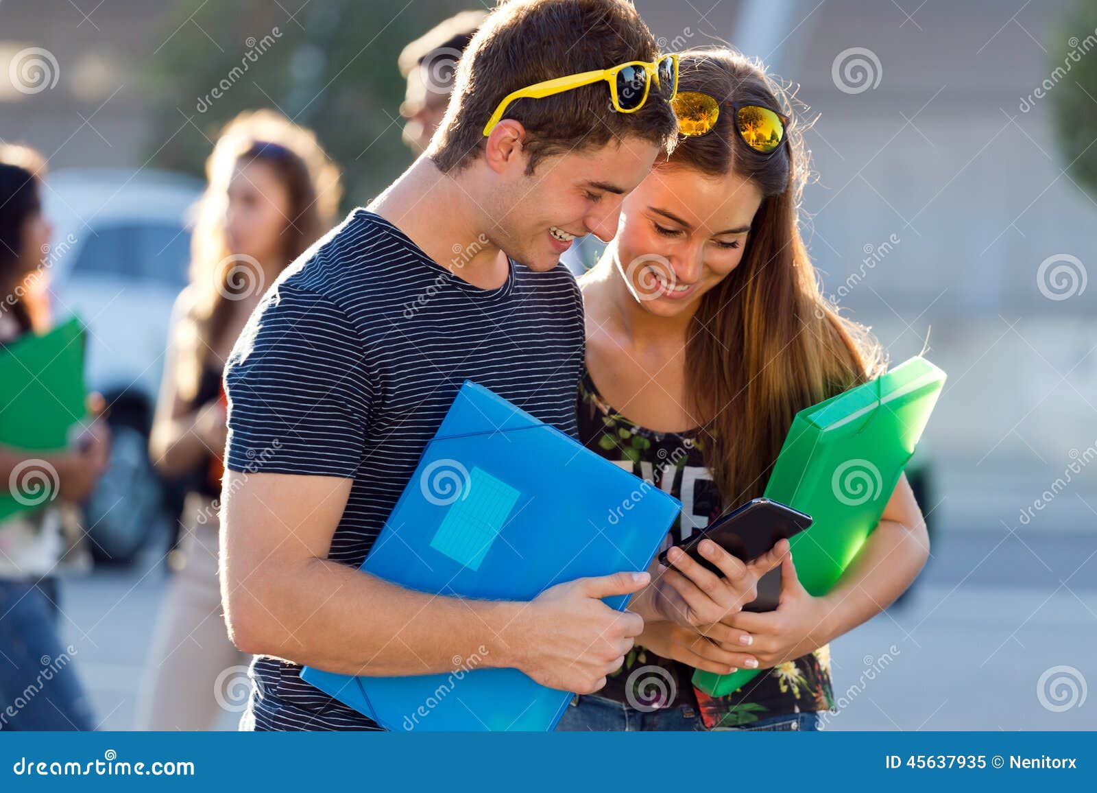 A Group of Students Having Fun with Smartphones after Class. Stock ...