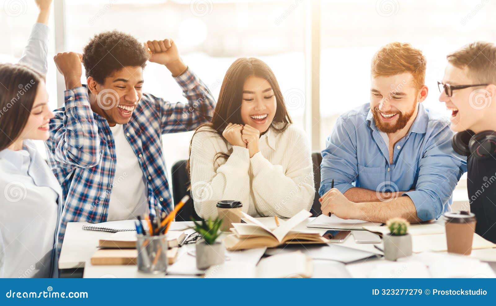Group of Students Sitting Around Table and Raising Arms Stock Image ...