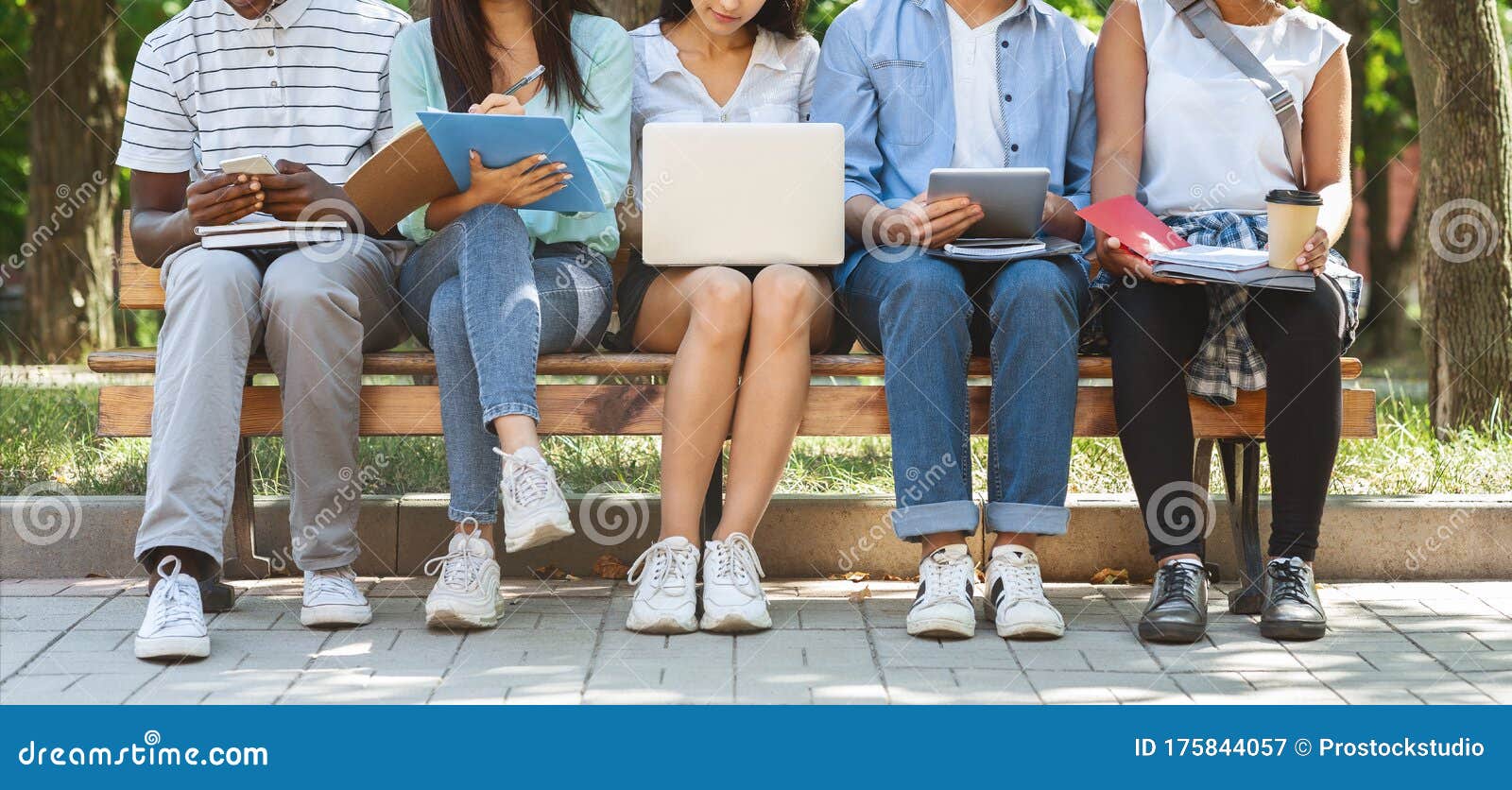 Group of Students Sitting on Bench Outdoors Preparing for Classes ...