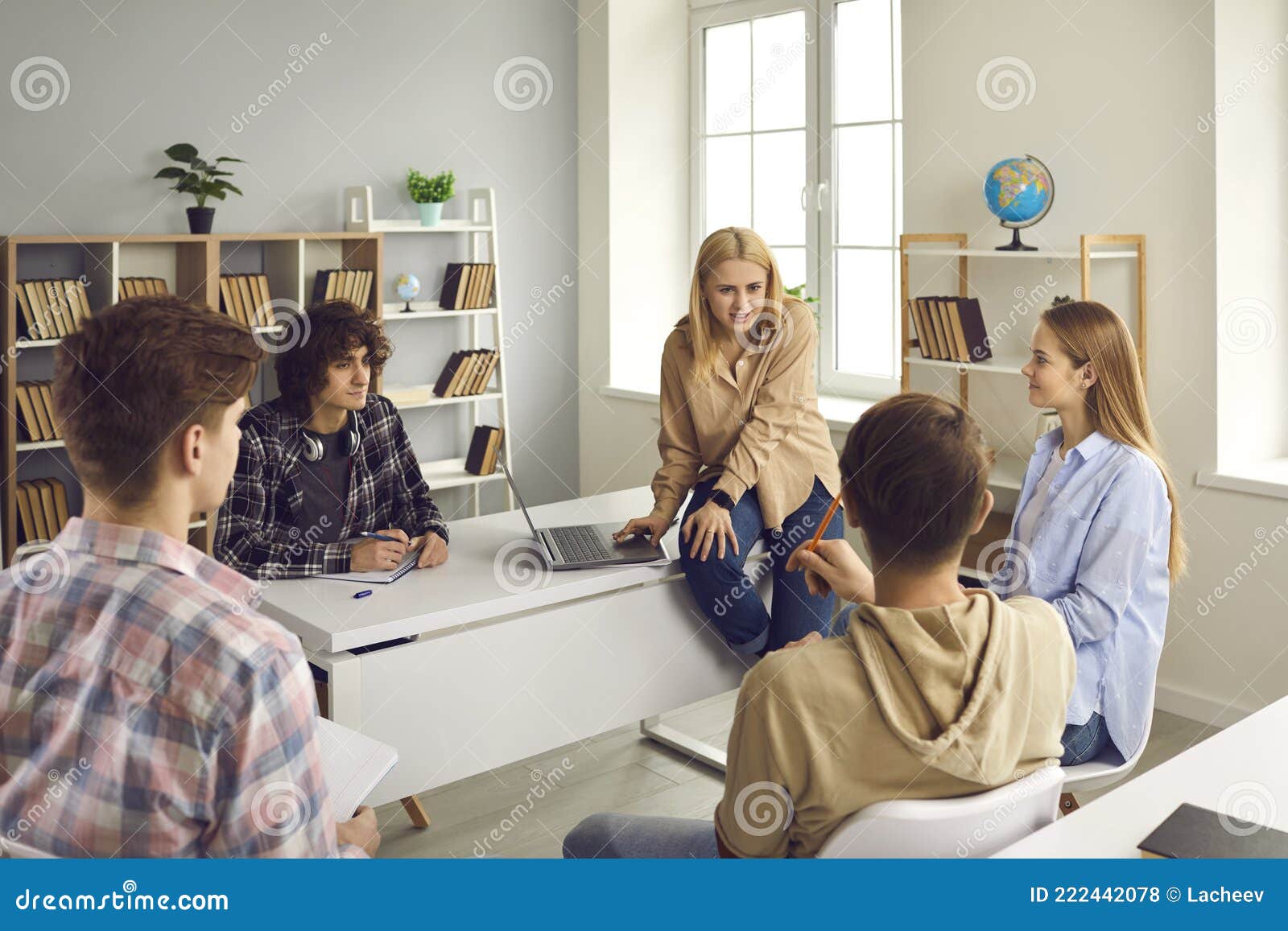 Students Sitting in a Classroom Working with a Laptop and Discussing a ...