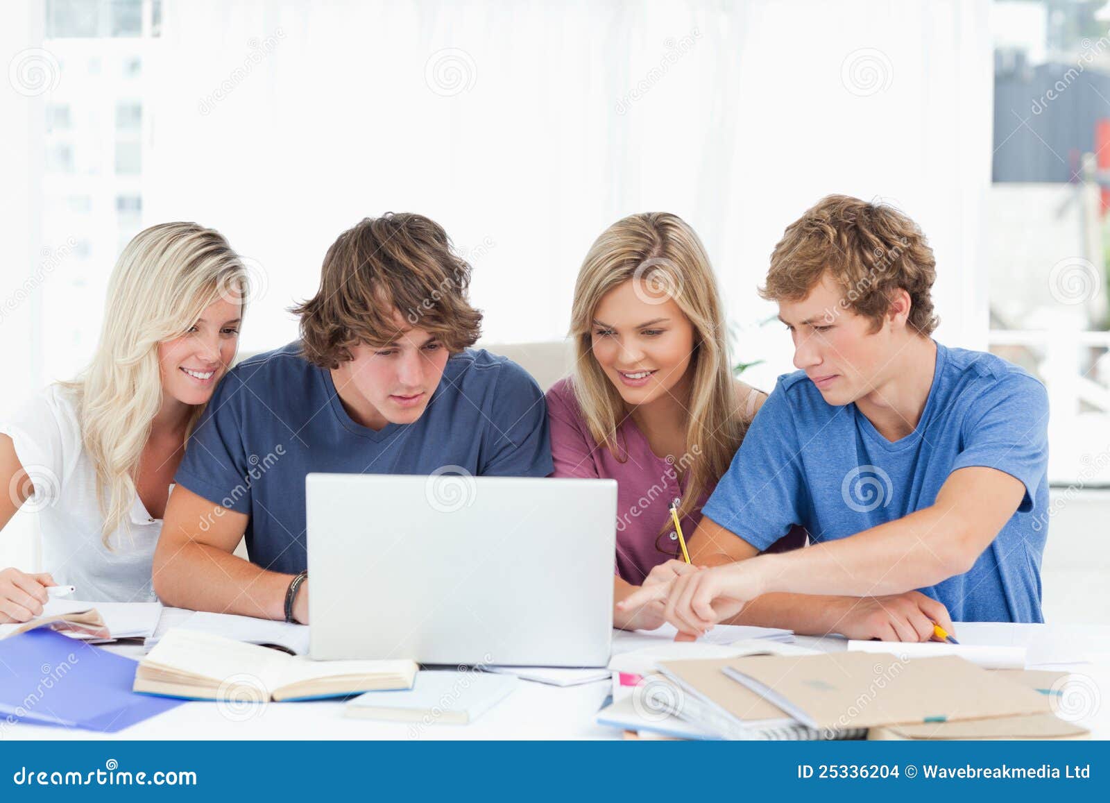 A Group of Students Use a Laptop To Answer Their Questions Stock Photo ...