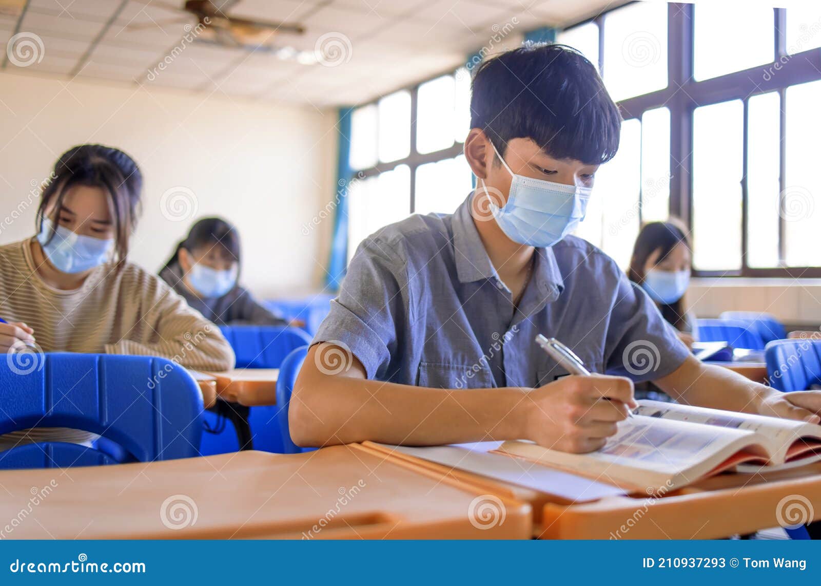Group of Students Wearing Protection Masks and Studying in Classroom ...