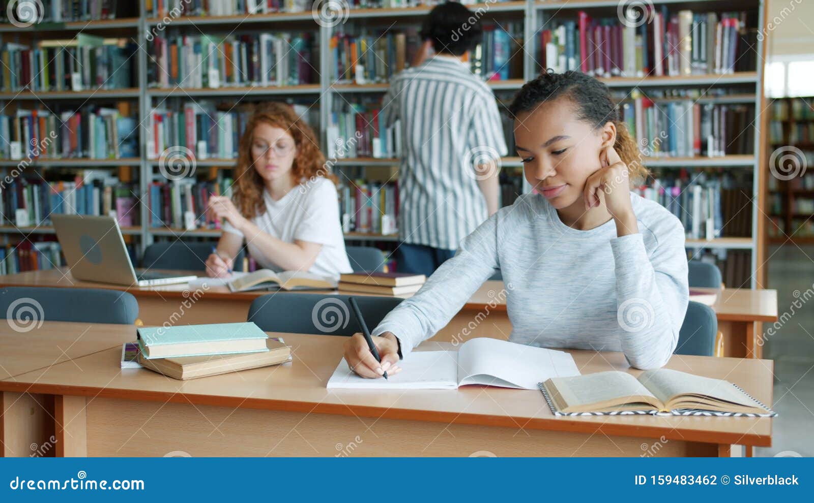 Group of Students Working in Library Reading Books Writing Studying ...