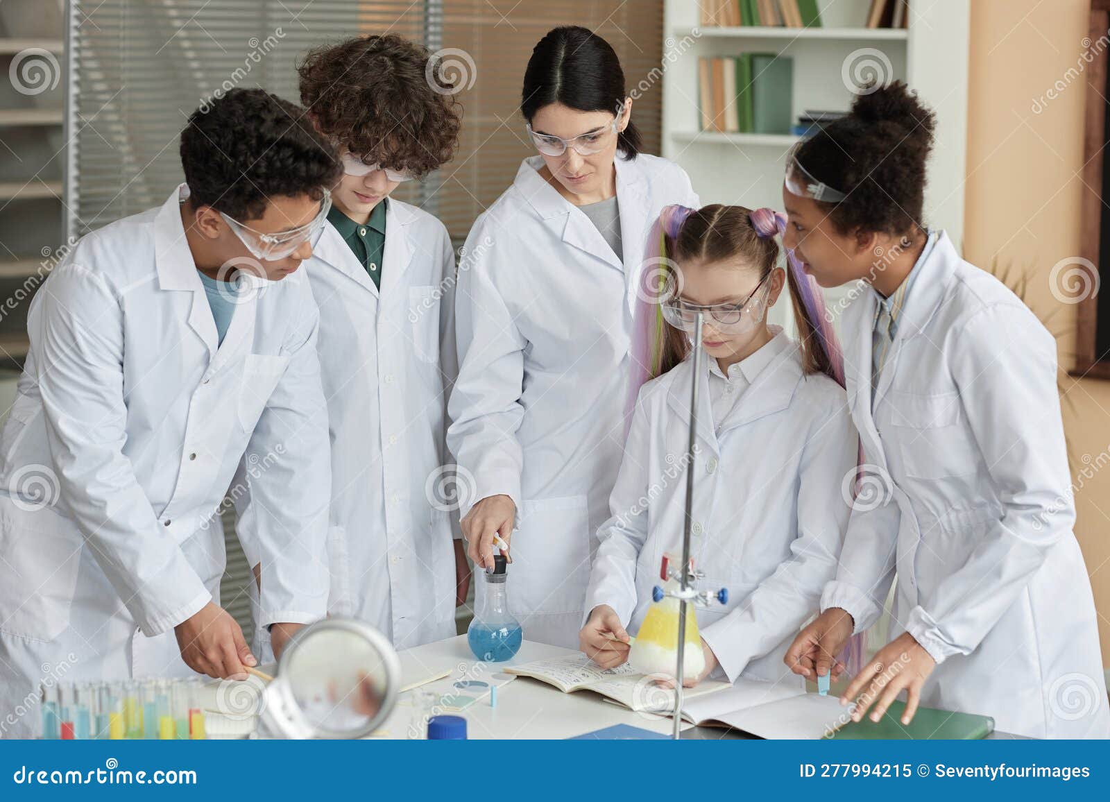 Group of Teens Wearing Lab Coats Doing Science Experiments in School ...