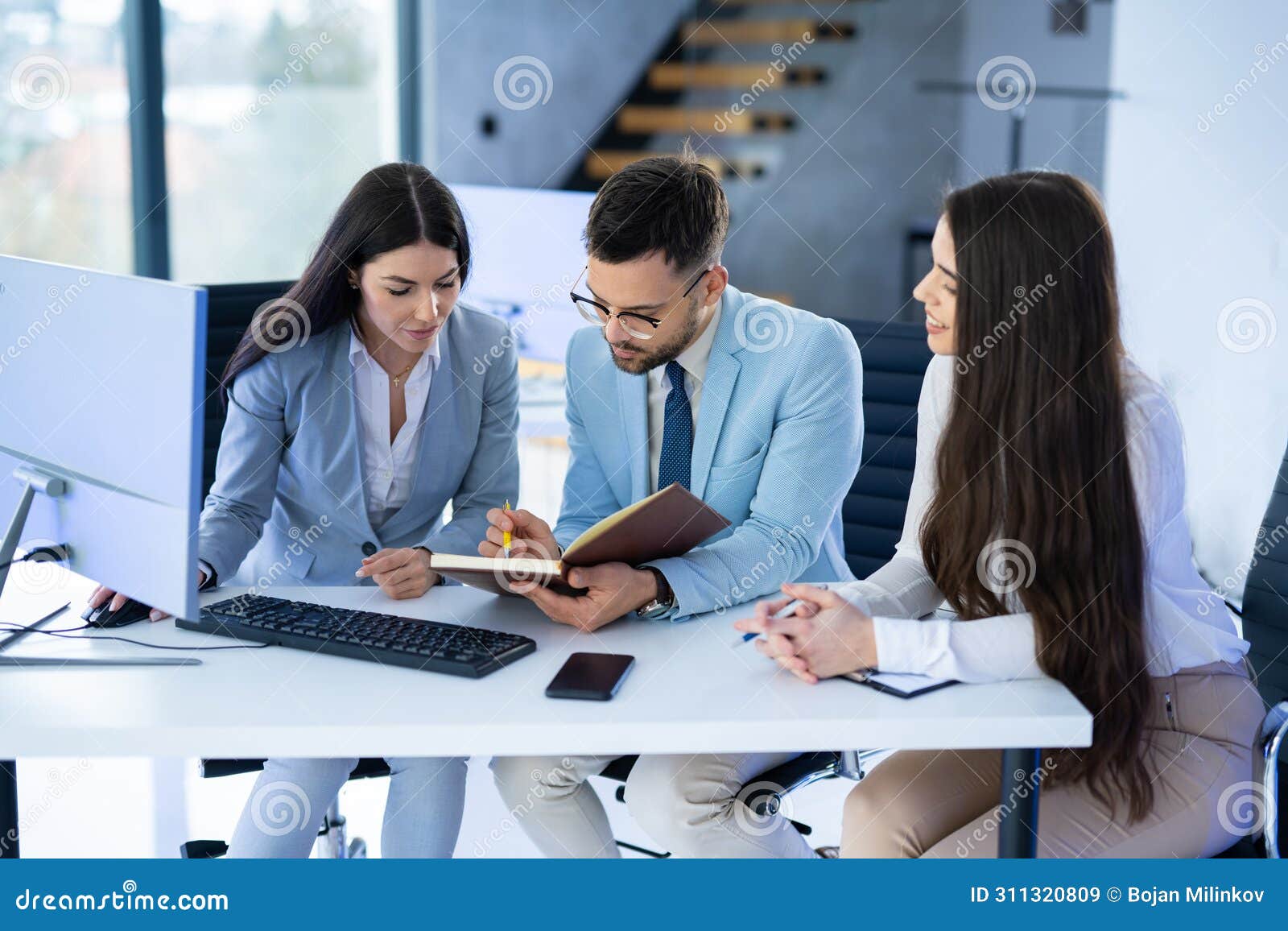 Group of Three Business People Checking Some Notes Together in the ...