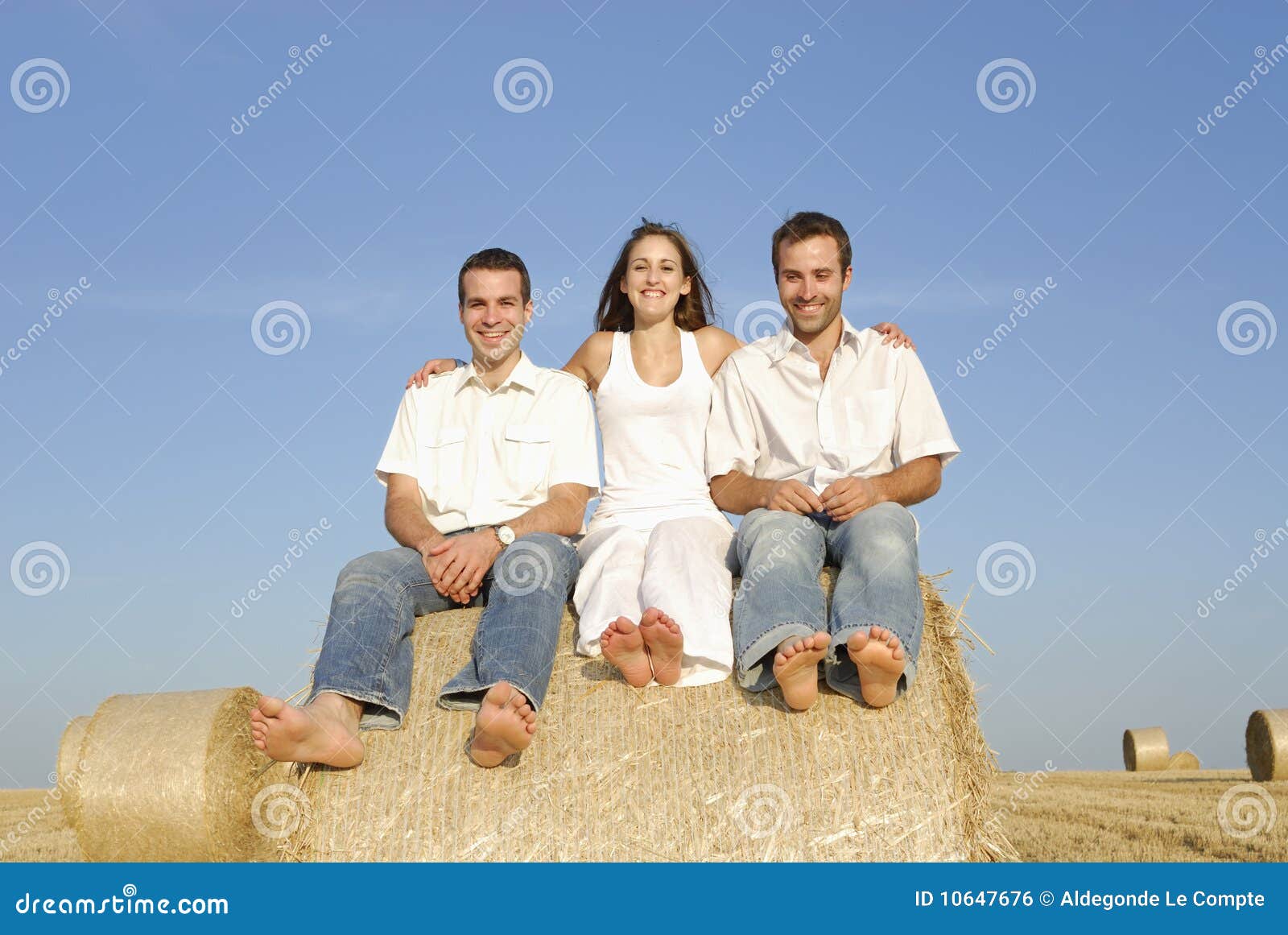 Group of Three Friends Sitting on a Straw Bale Stock Photo - Image of ...