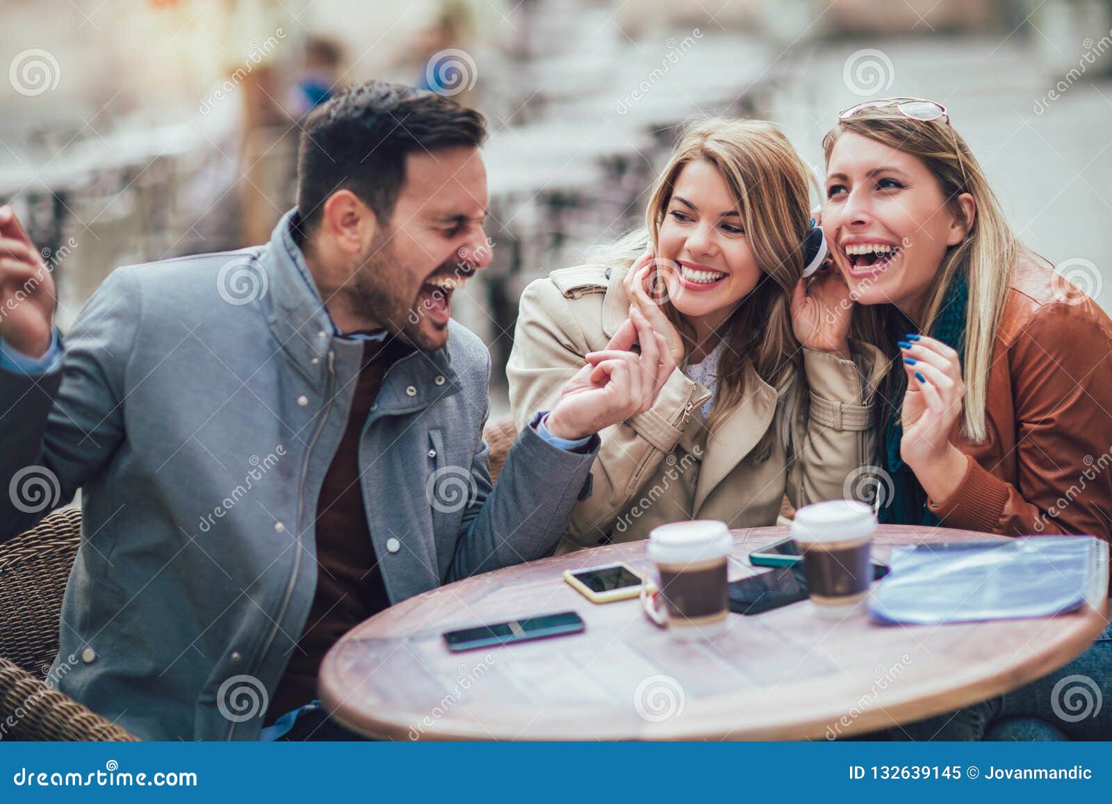 Group of Three Friends Using Phone in Outdoor Cafe Stock Image - Image ...