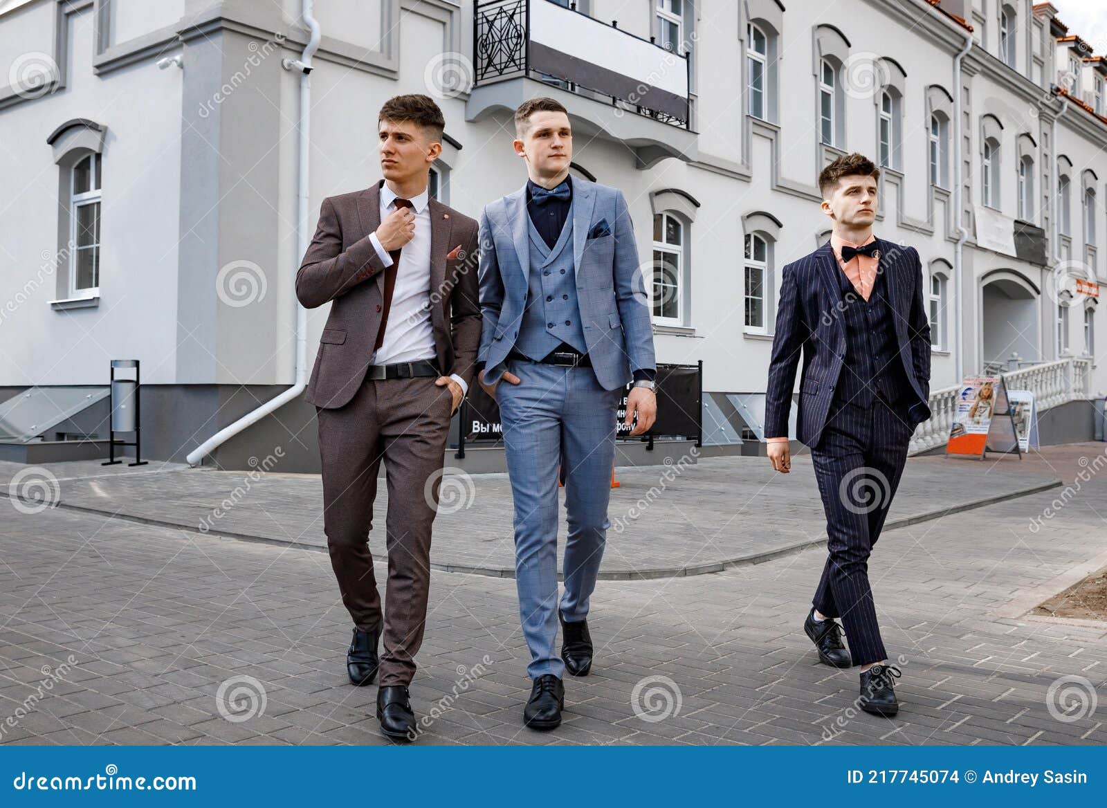 A Group of Three People in Stylish Suits Against the Backdrop of the ...
