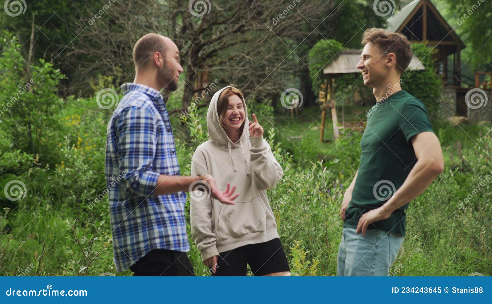 A Group of Three People are Talking and Laughing while Standing in a ...