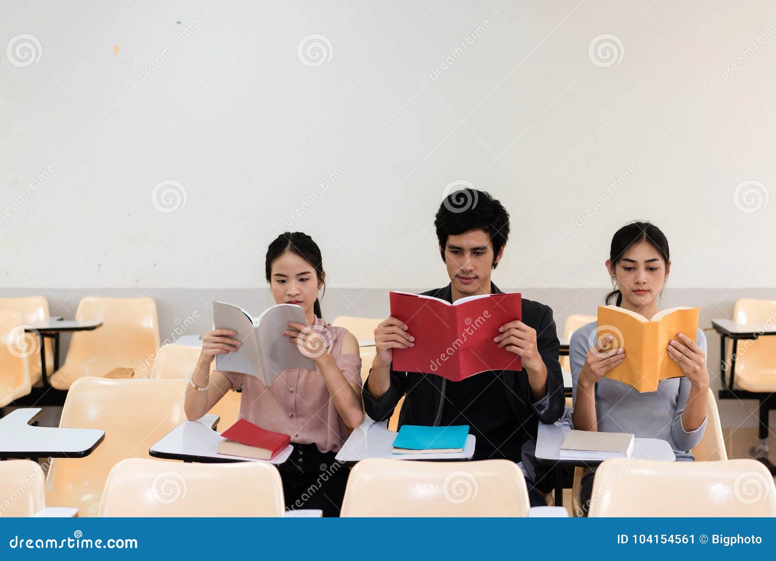 Group of Three Students Reading Book Together in Classroom Stock Image ...