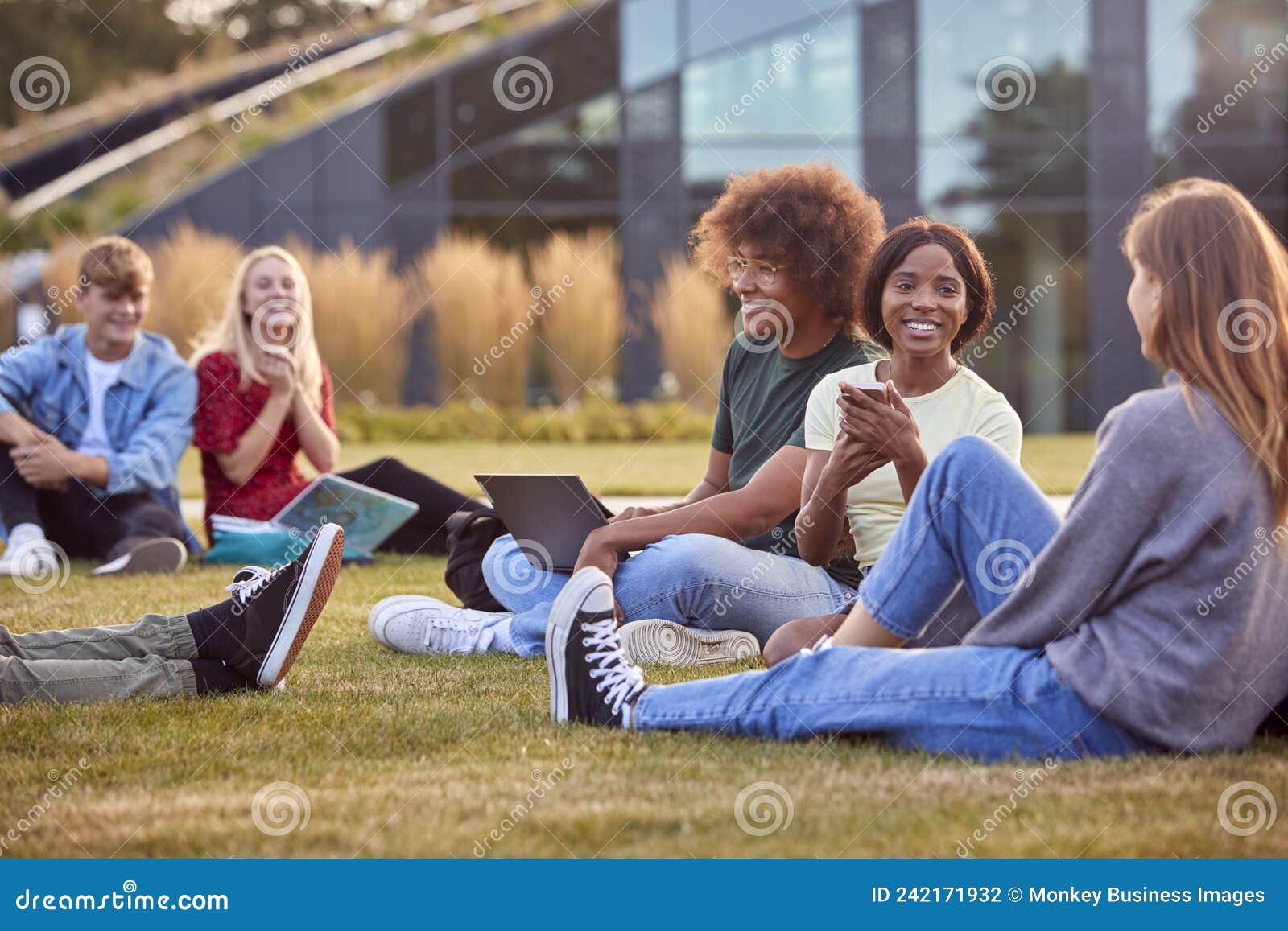Group of University or College Students Sit on Grass Outdoors on Campus ...