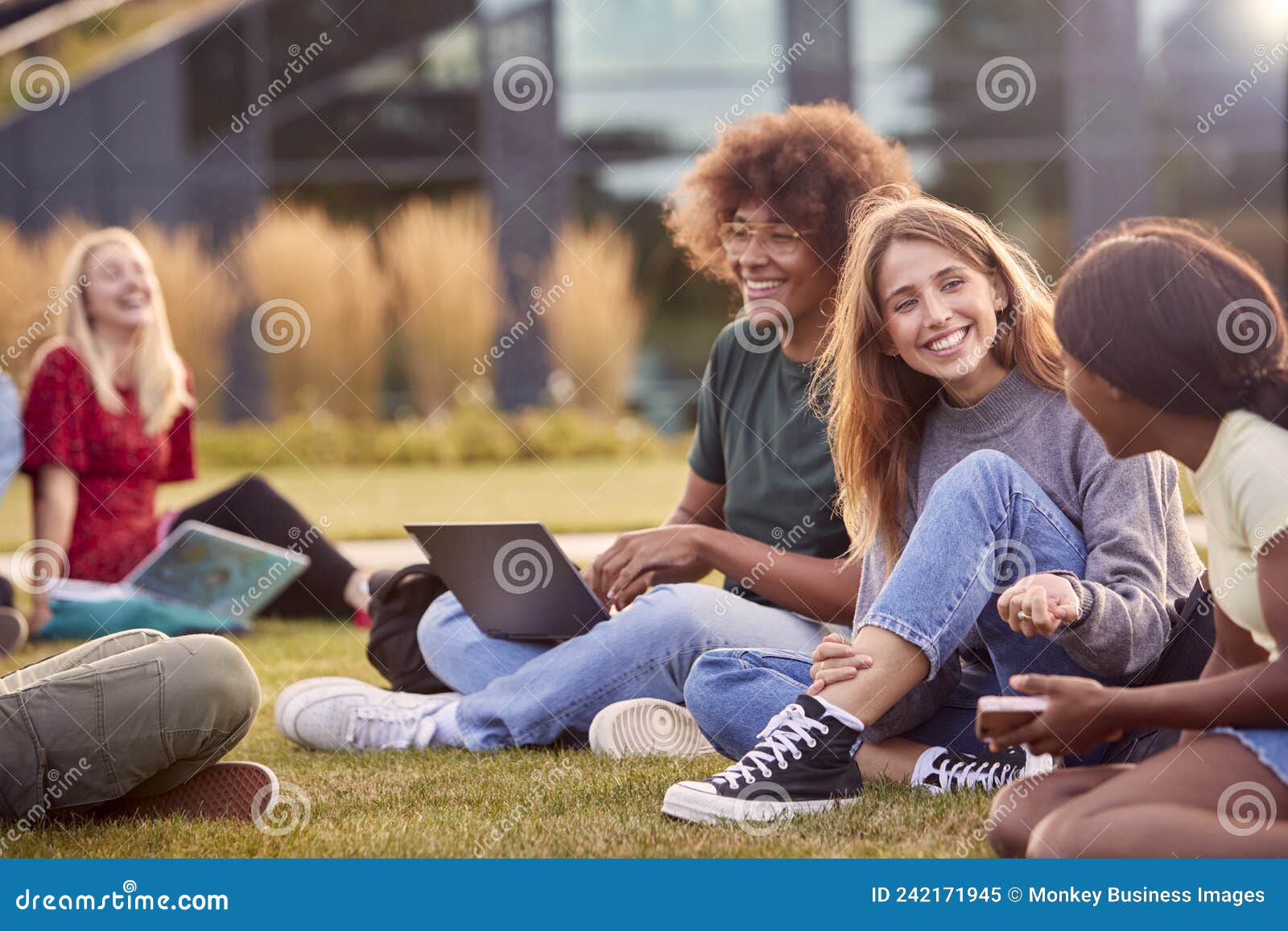 Group of University or College Students Sit on Grass Outdoors on Campus ...