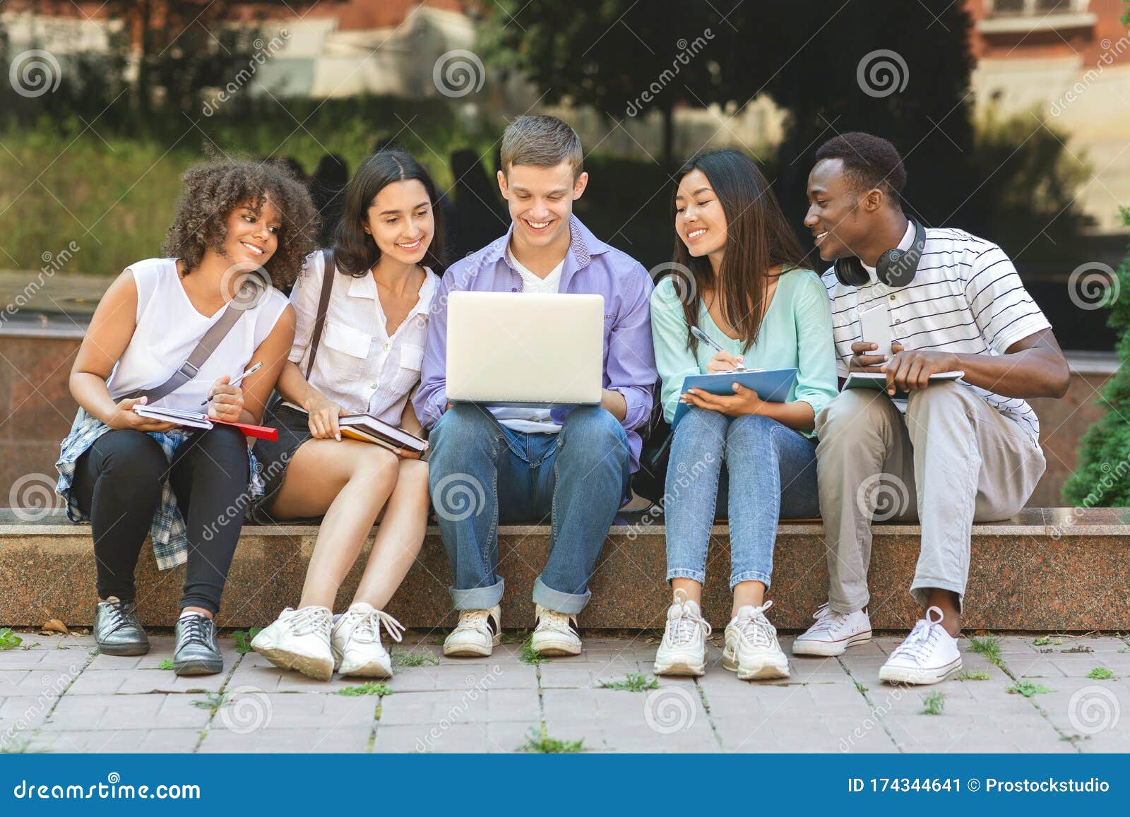 Group of University Students Using Laptop Outdoors, Preparing for ...