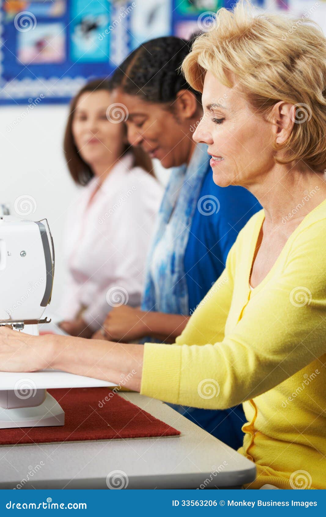 Group of Women Using Electric Sewing Machines in Class Stock Photo ...