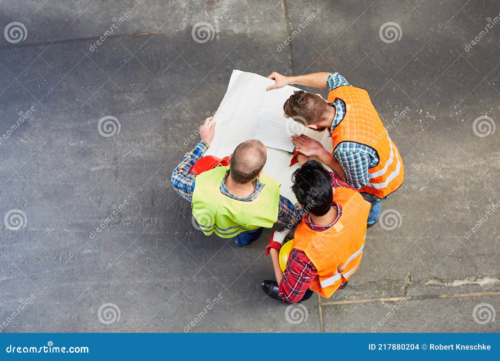 Group of Workers with Architectural Drawing on Construction Site from ...