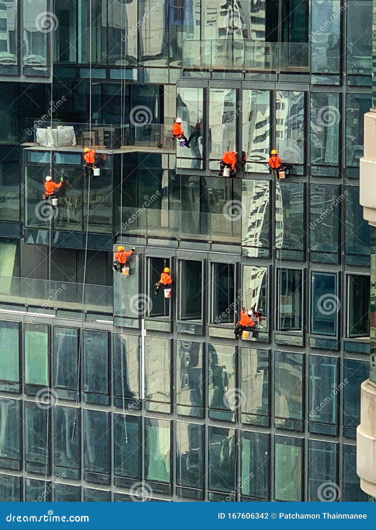 A Group of Workers are Cleaning the Glass on a High-rise Building ...