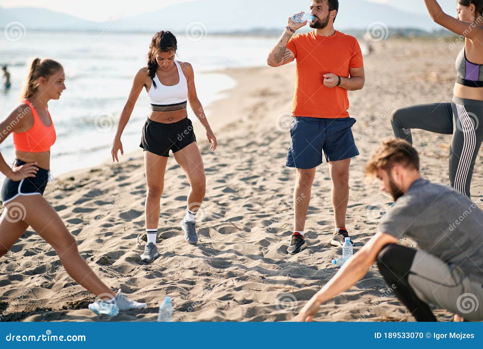 Group of Young Adults Doing Exercises on Sandy Beach. Beardy Guy ...