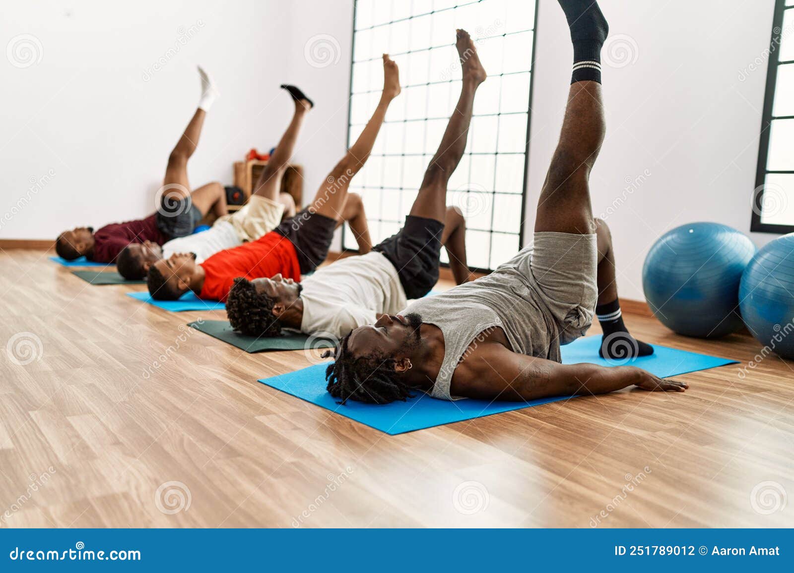 Group of Young African American Man Training Abs Exercise at Sport ...