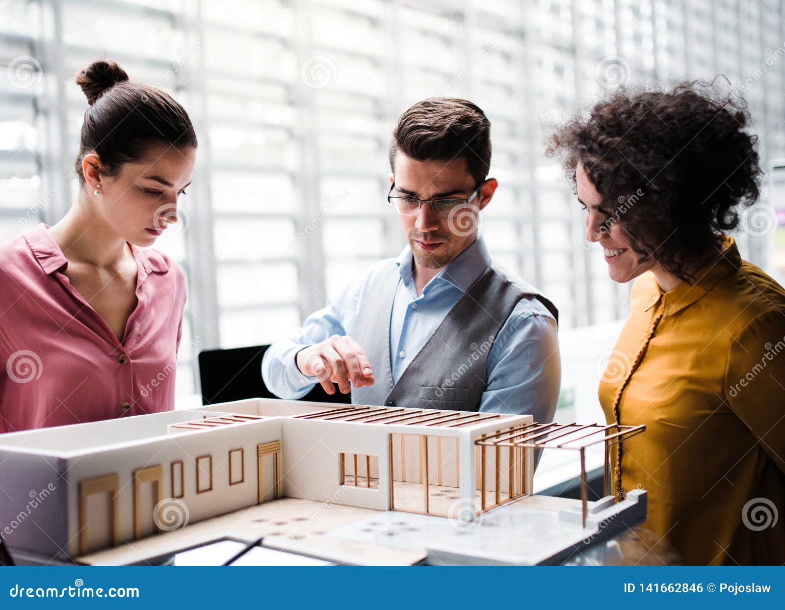 Group of Young Architects with Model of a House Standing in Office ...