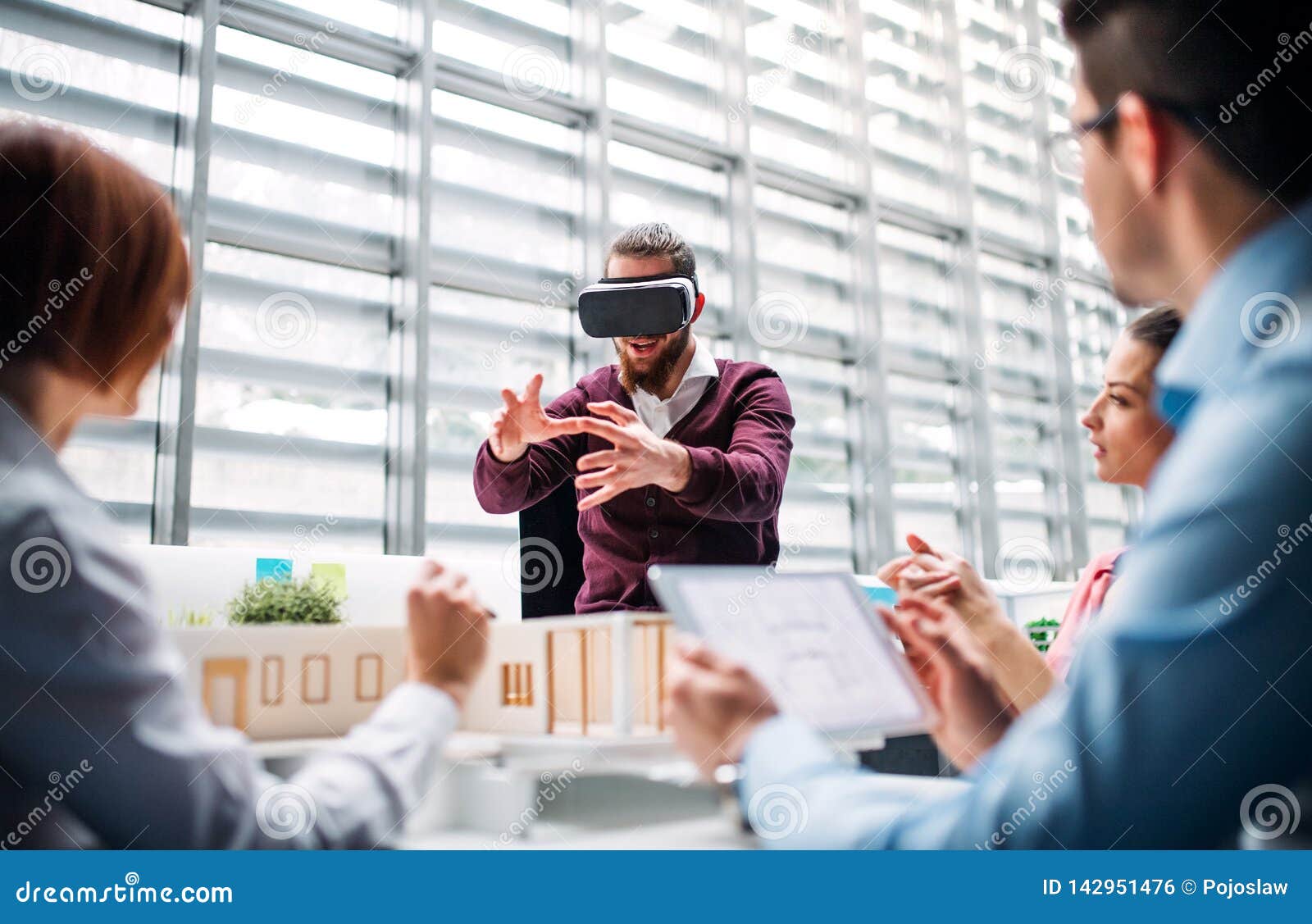 Group of Young Architects with Model of a House and VR Goggles Working ...