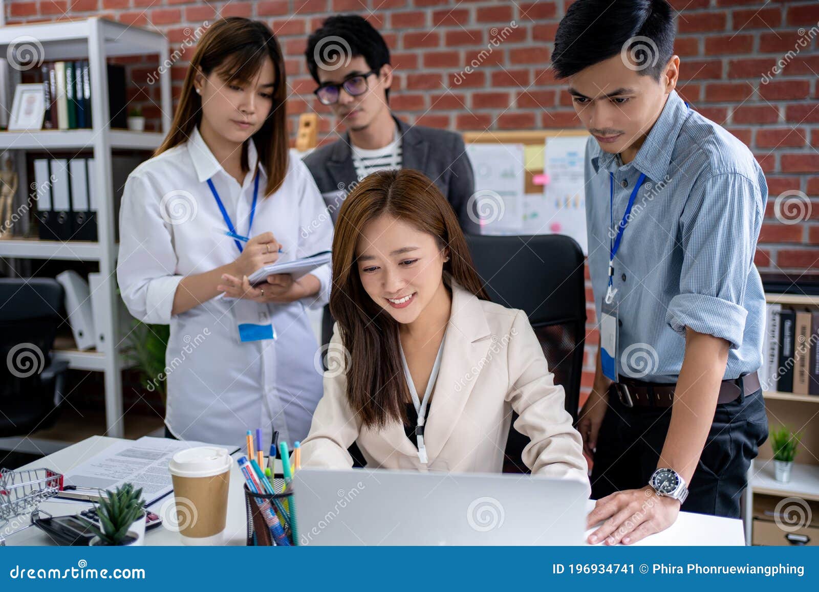 A Group of Young Asian Businessmen is Analyzing Graphs on Computers at ...