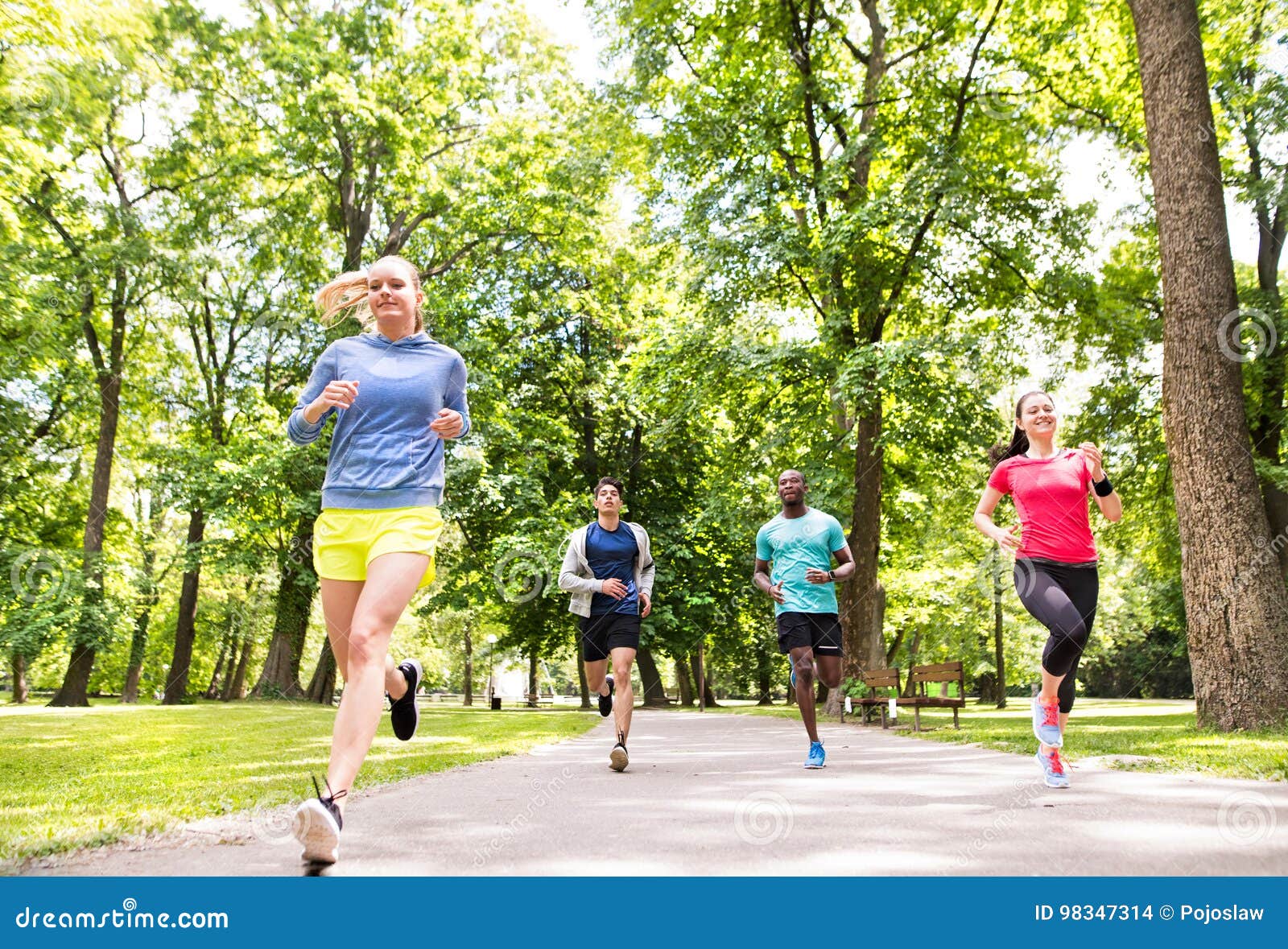 Group of Young Athletes Running in Green Sunny Park. Stock Photo ...