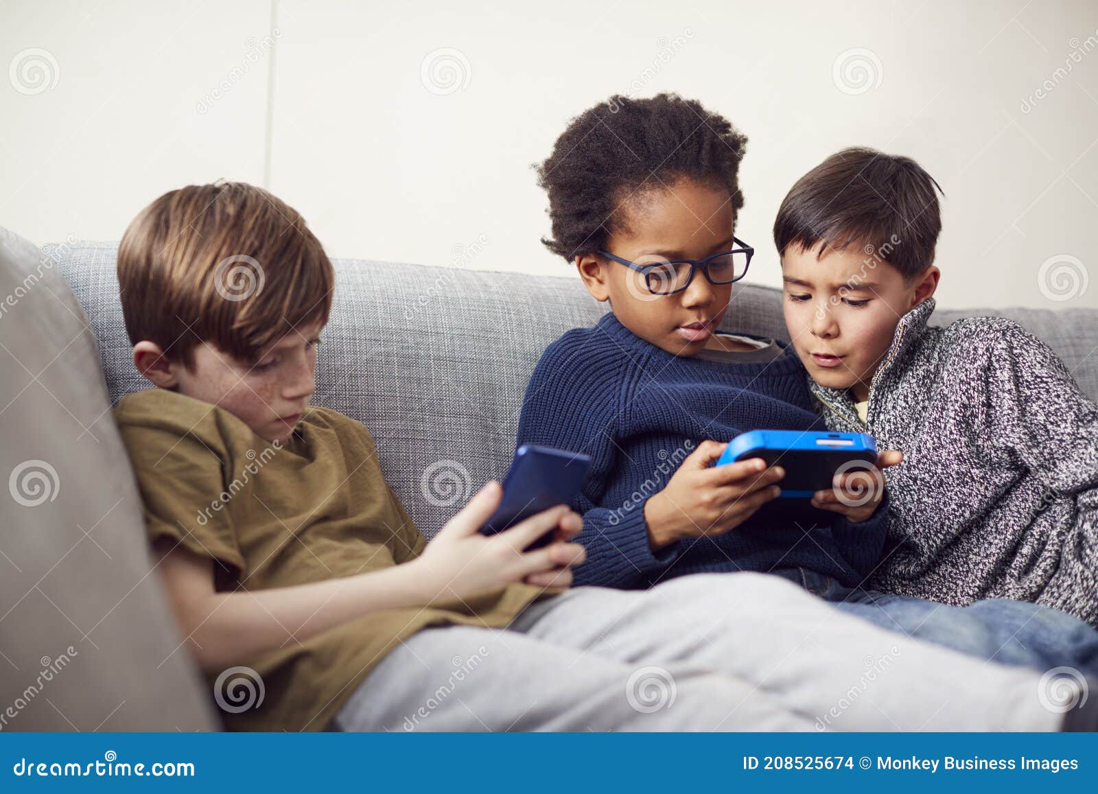 Group of Young Boys Gaming Together on Hand Held Devices at Home Stock ...