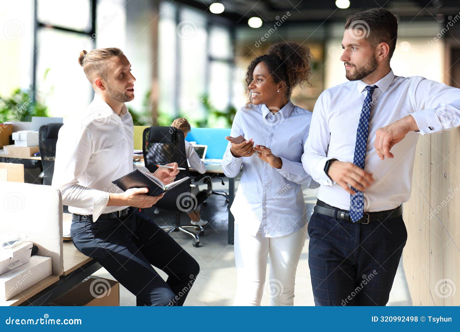 Group of Young Business People Discussing Something while Working in ...