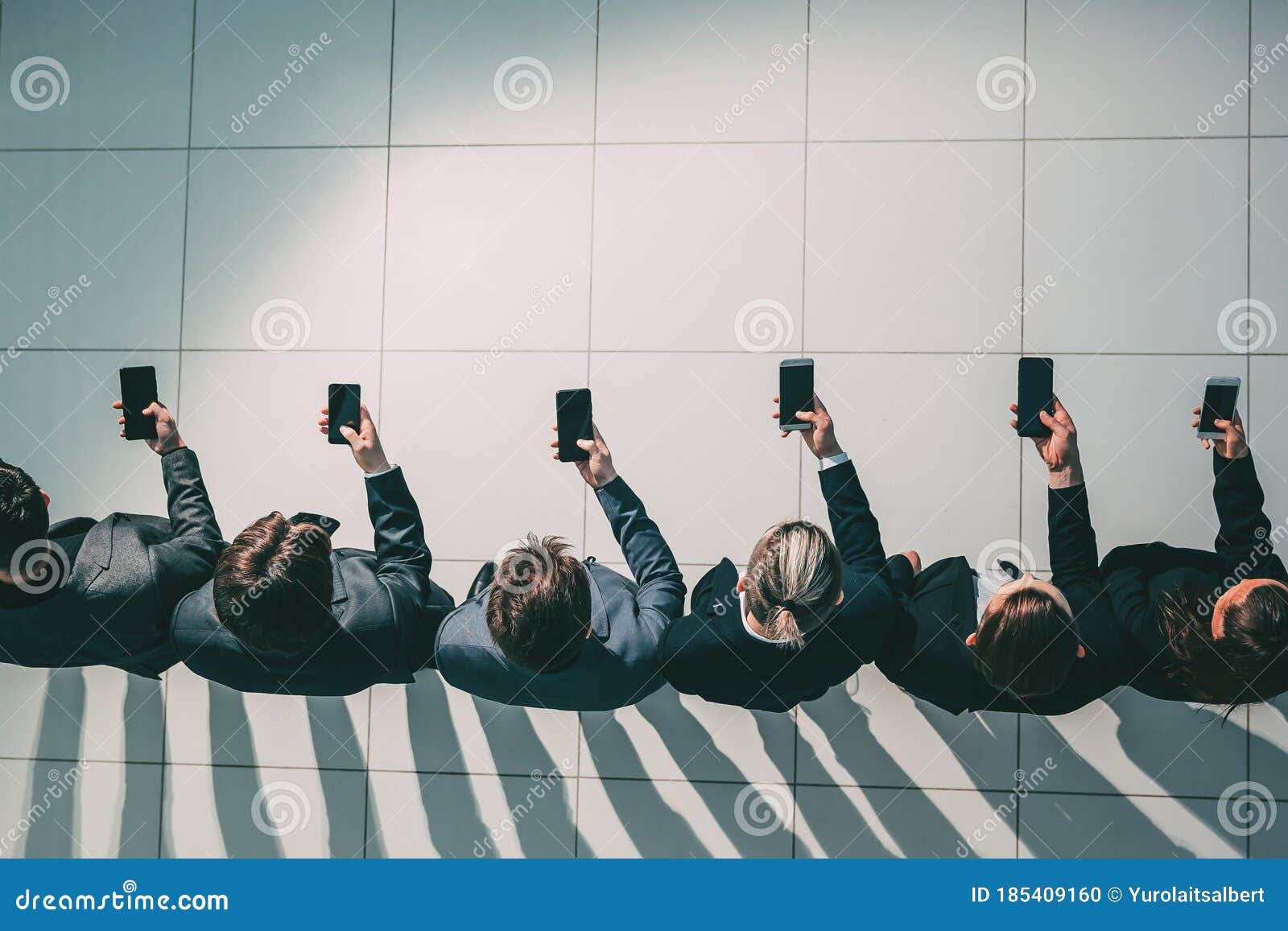 Group of Young Business People Looking at Their Smartphone Screens ... Group of Young Business People Looking at Their Smartphone Screens ...