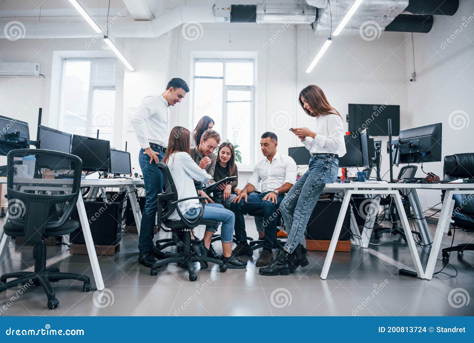 Group of Young Business People that Standing and Sitting and Working in ...