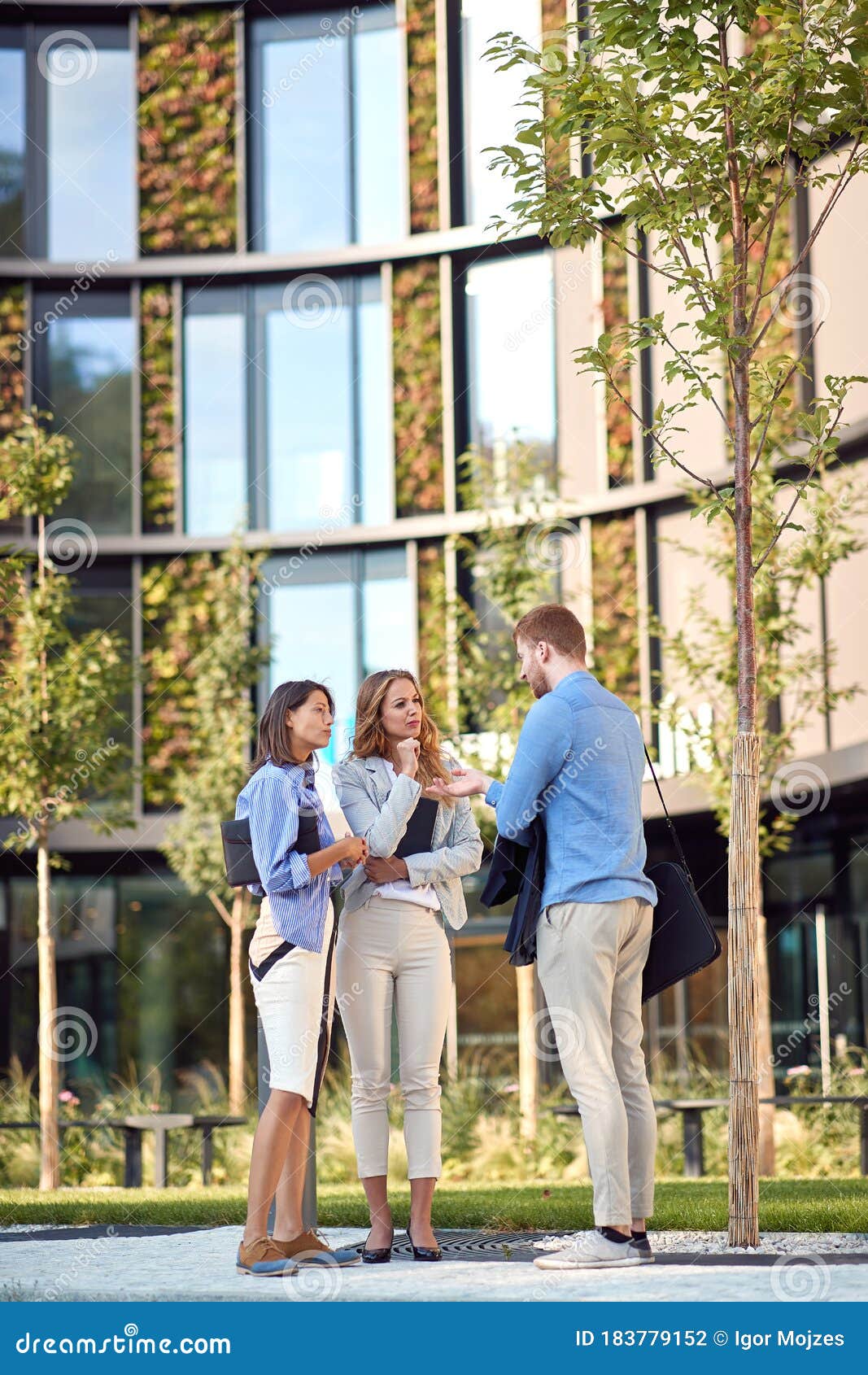 Group of Young Business People Talking in Front of a Building. Vertical ...