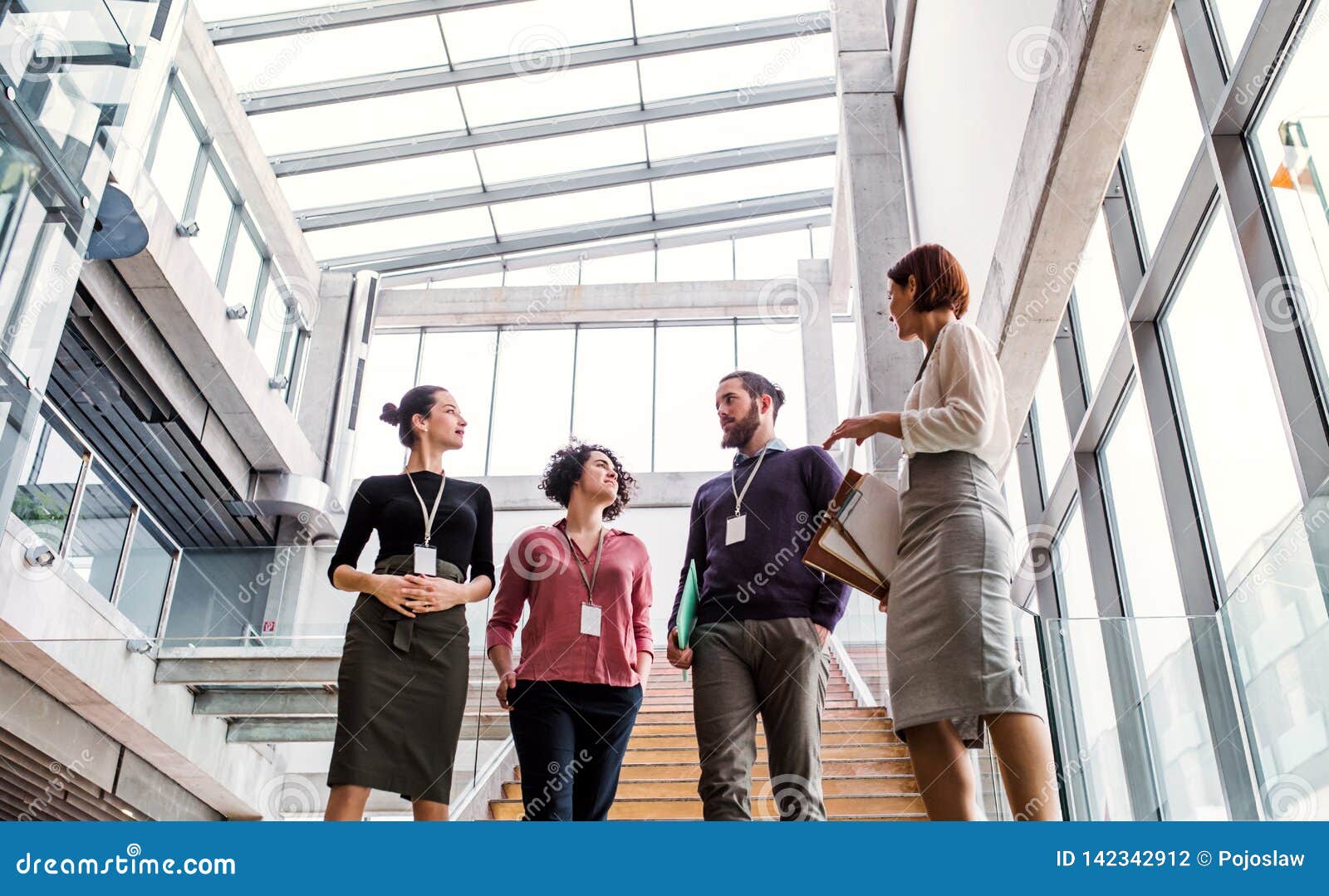 Group of Young Businesspeople Walking Down the Stairs, Talking. Stock ...