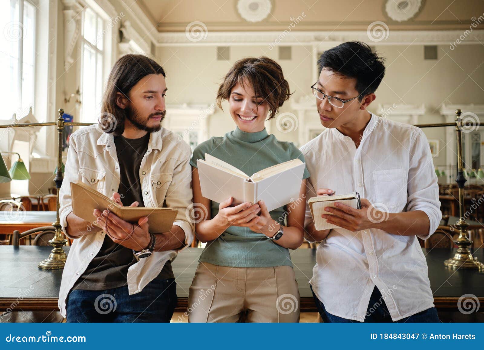 Group of Young Casual Multinational Students Happily Studying with Book ...