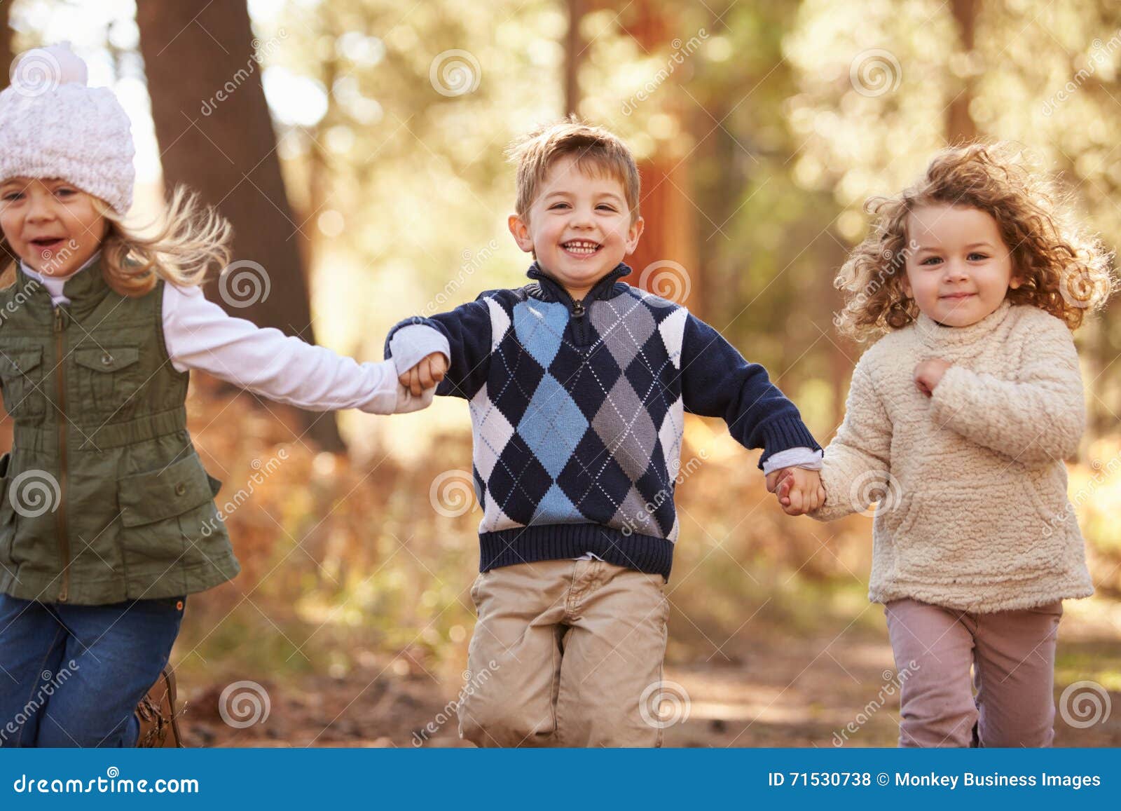 Group of Young Children Running Along Path in Autumn Forest Stock Photo ...