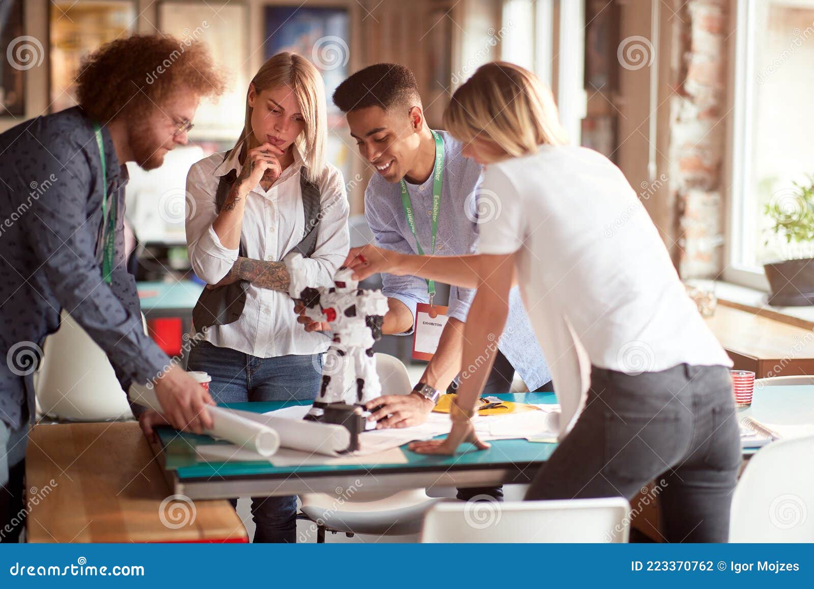 Group of Young Creative People is Analyzing a Robot Toy at Work in the ...