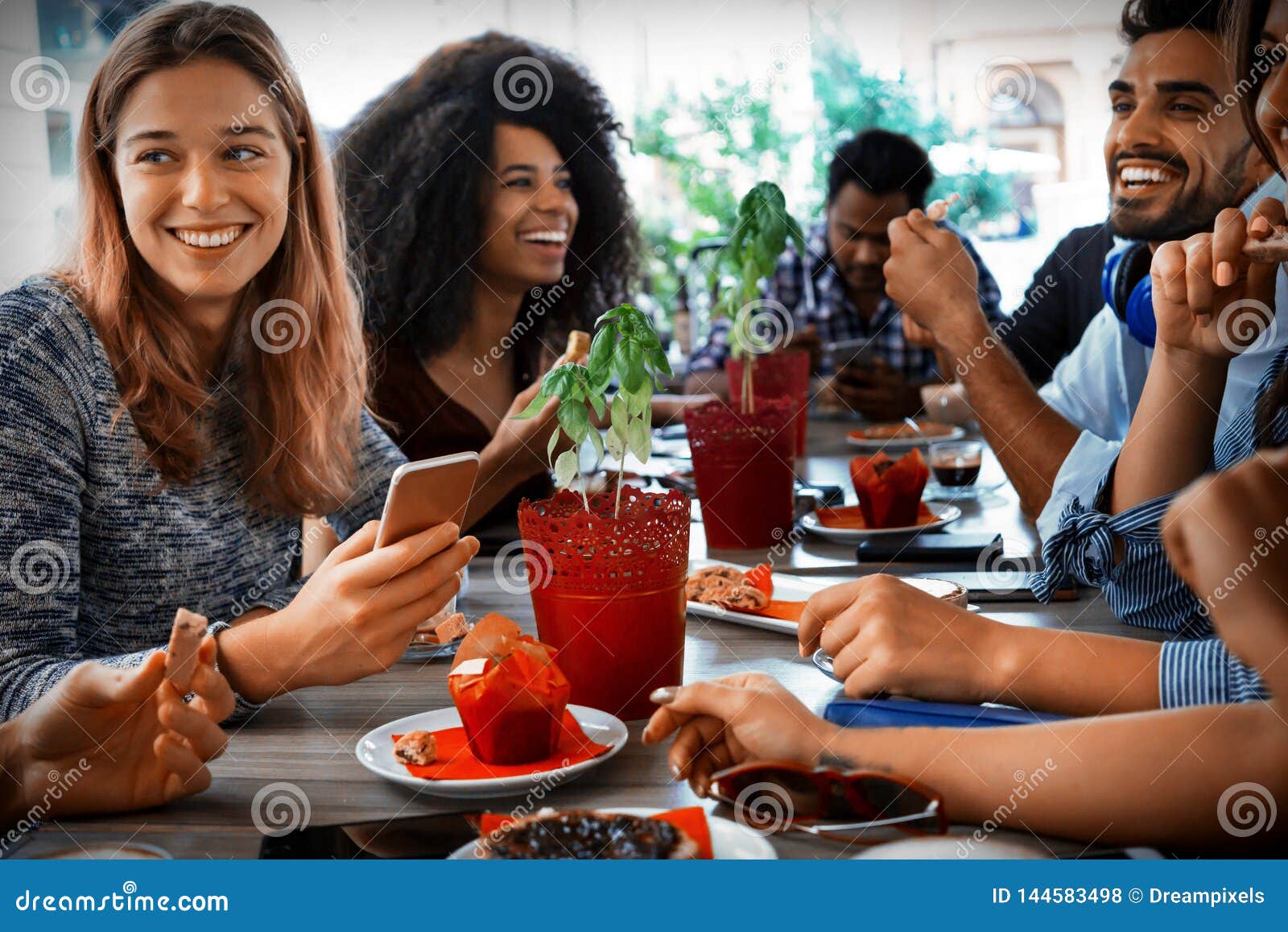 Group of Young Diverse People Sitting at Restaurant Table Having a Meal ... Group of Young Diverse People Sitting at Restaurant Table Having a Meal ...