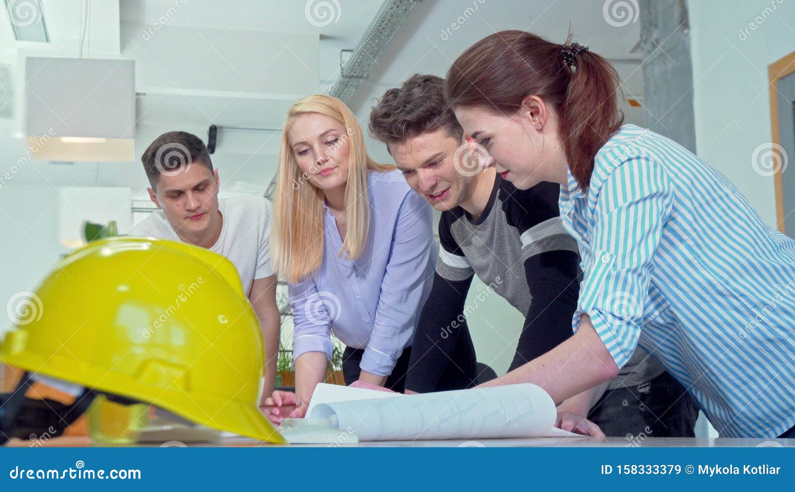 Group of Young Engineers Discussing Architectural Blueprints Stock ...