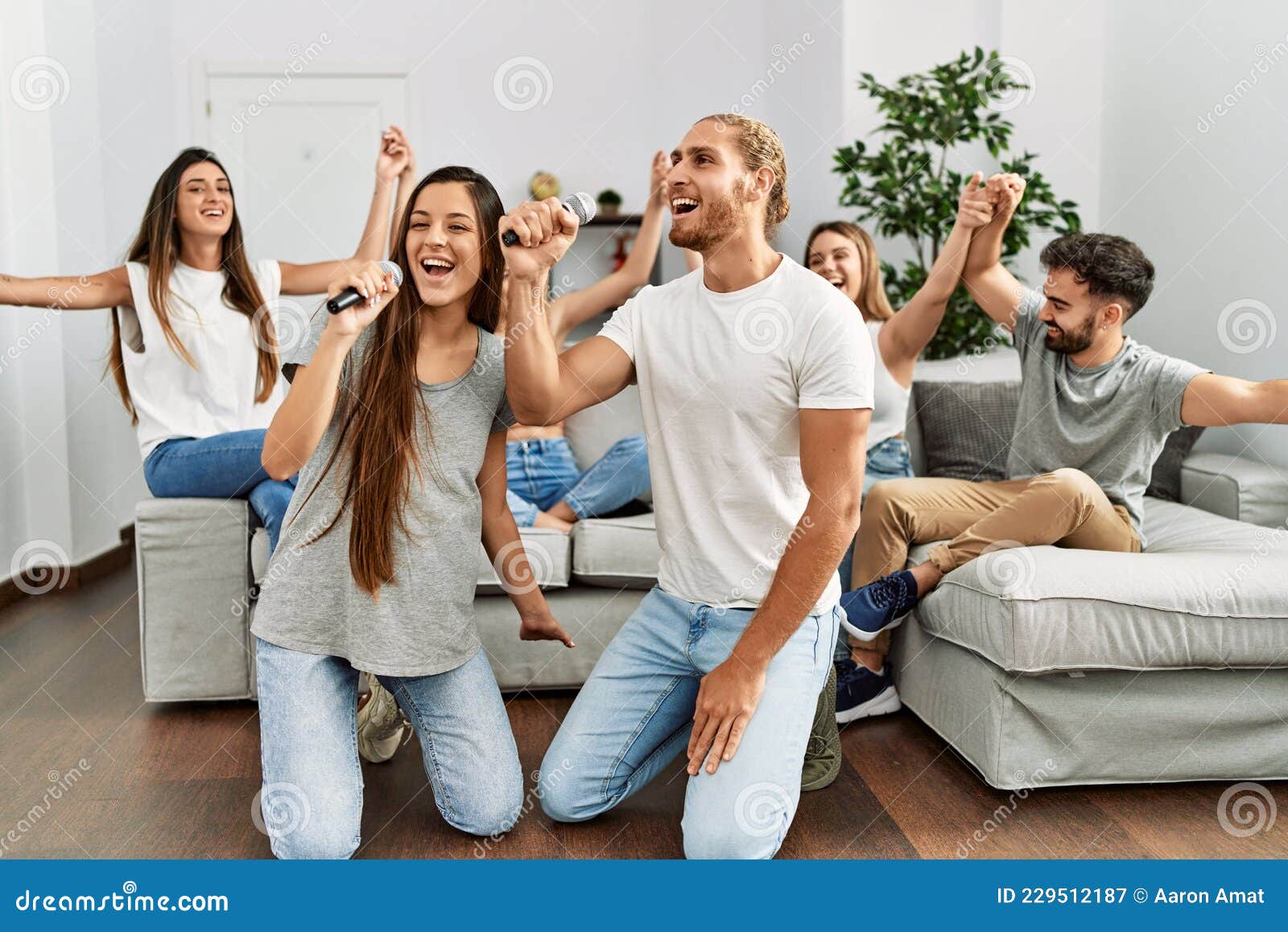 Group of Young Friends Having Party Singing Song Using Microphone at ...