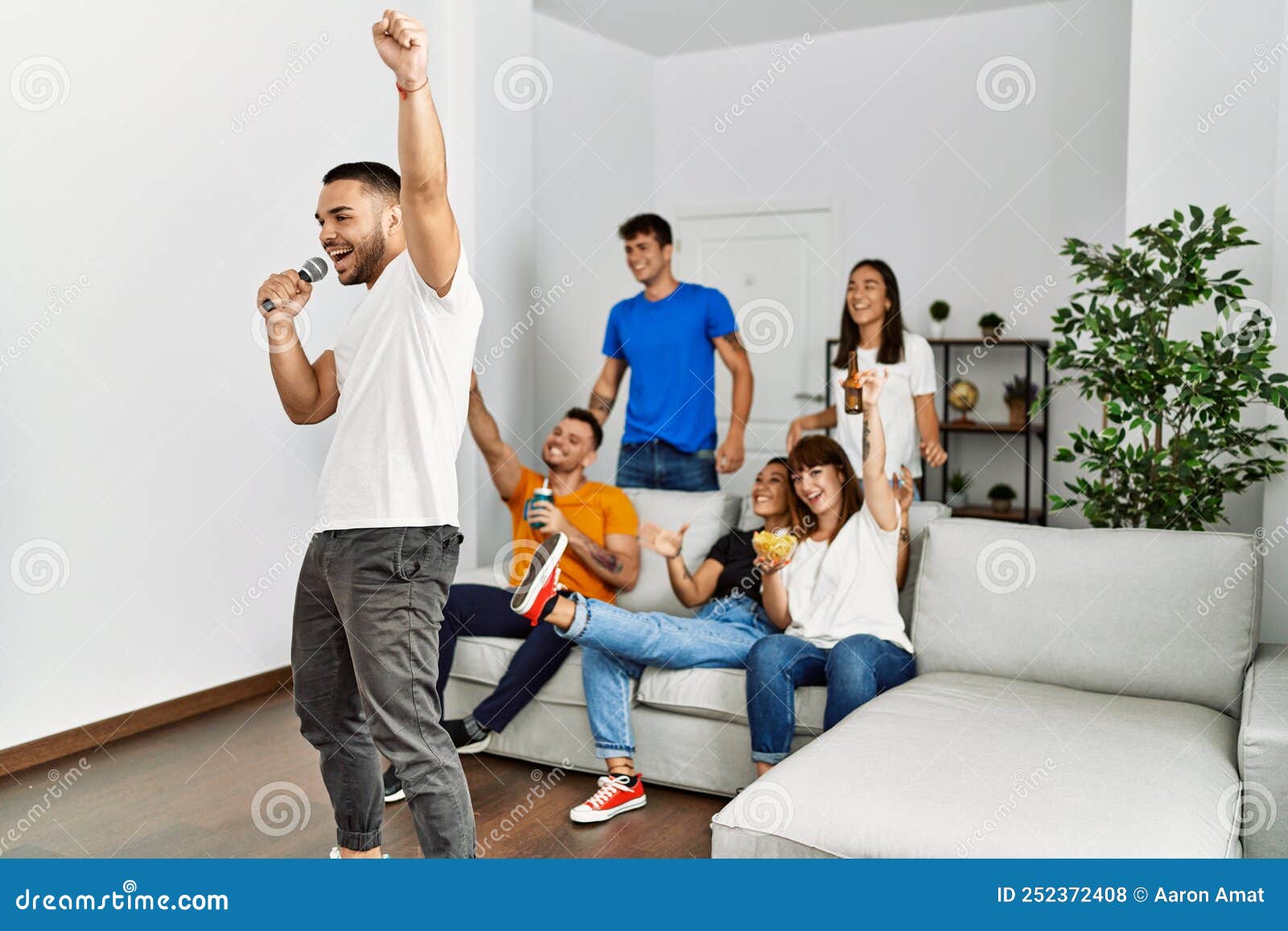 Group of Young Friends Having Party Singing Song Using Microphone at ...