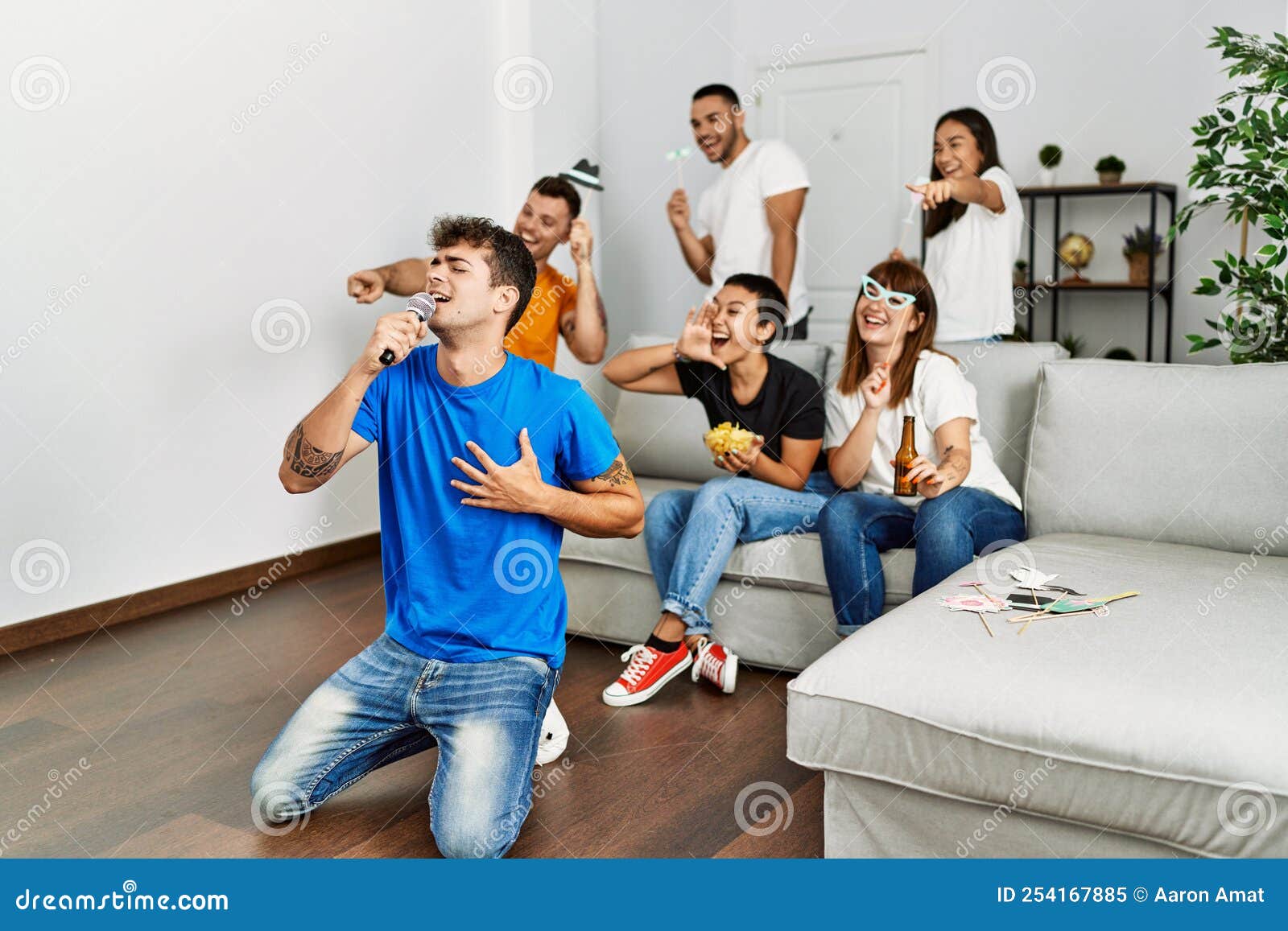 Group of Young Friends Having Party Singing Song Using Microphone at ...