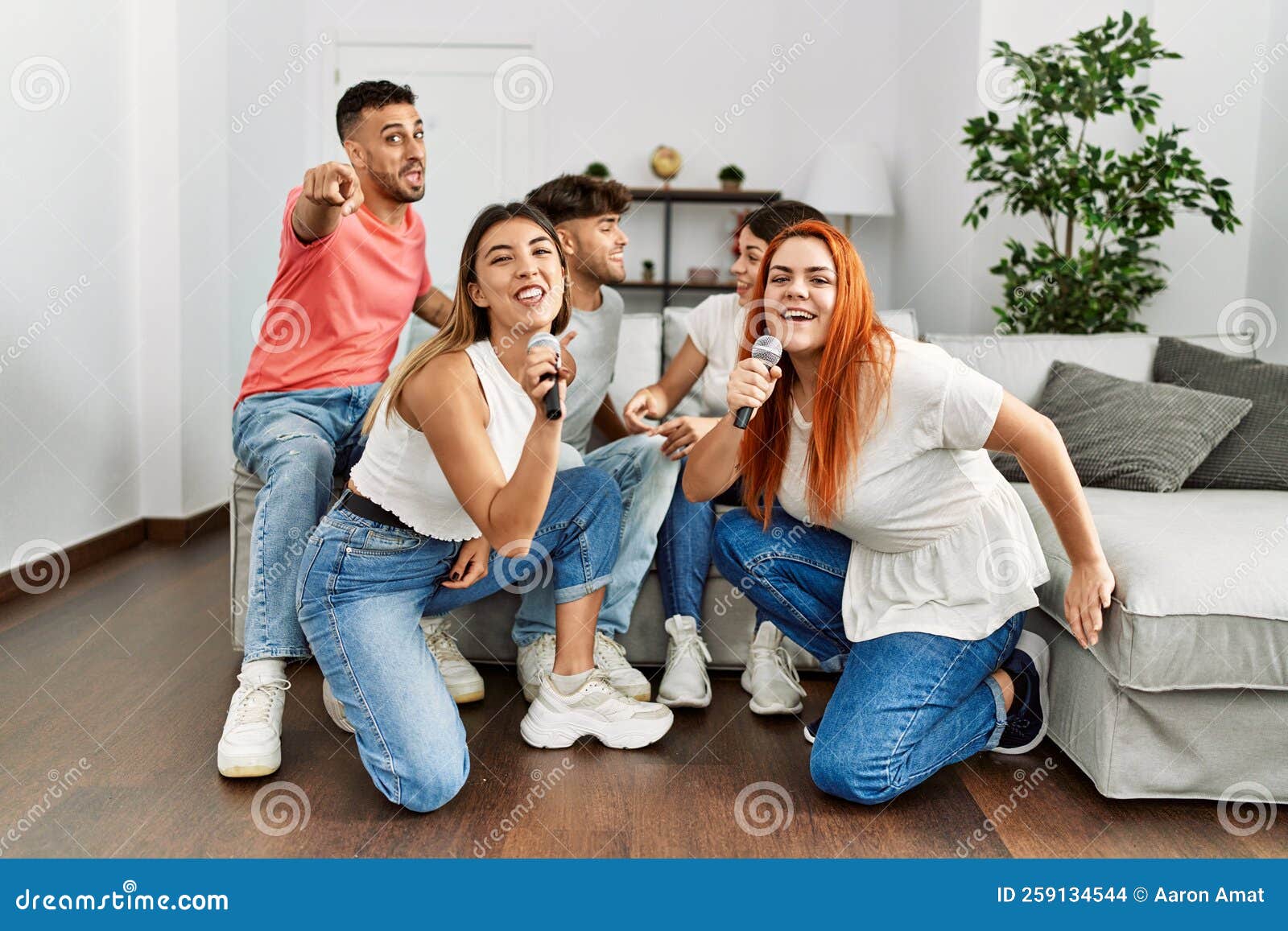 Group of Young Friends Having Party Singing Song Using Microphone at ...