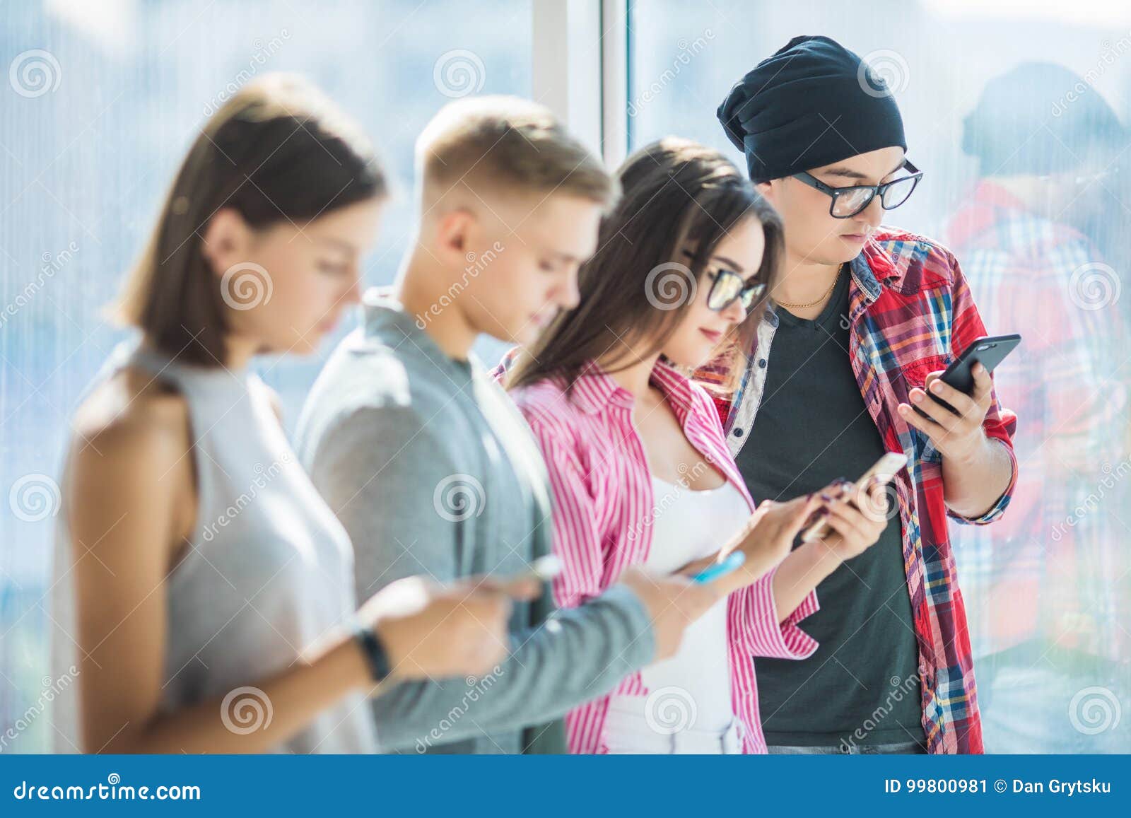 Group of Young Friends Looking at Their Smart Phones without ...