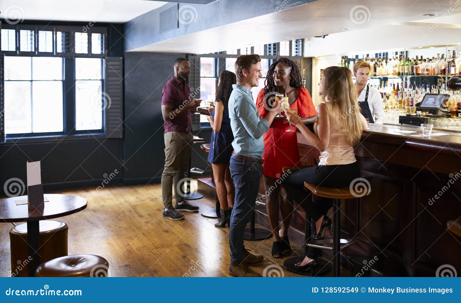 Group of Young Friends Relaxing in Bar Standing at Counter Stock Image ...