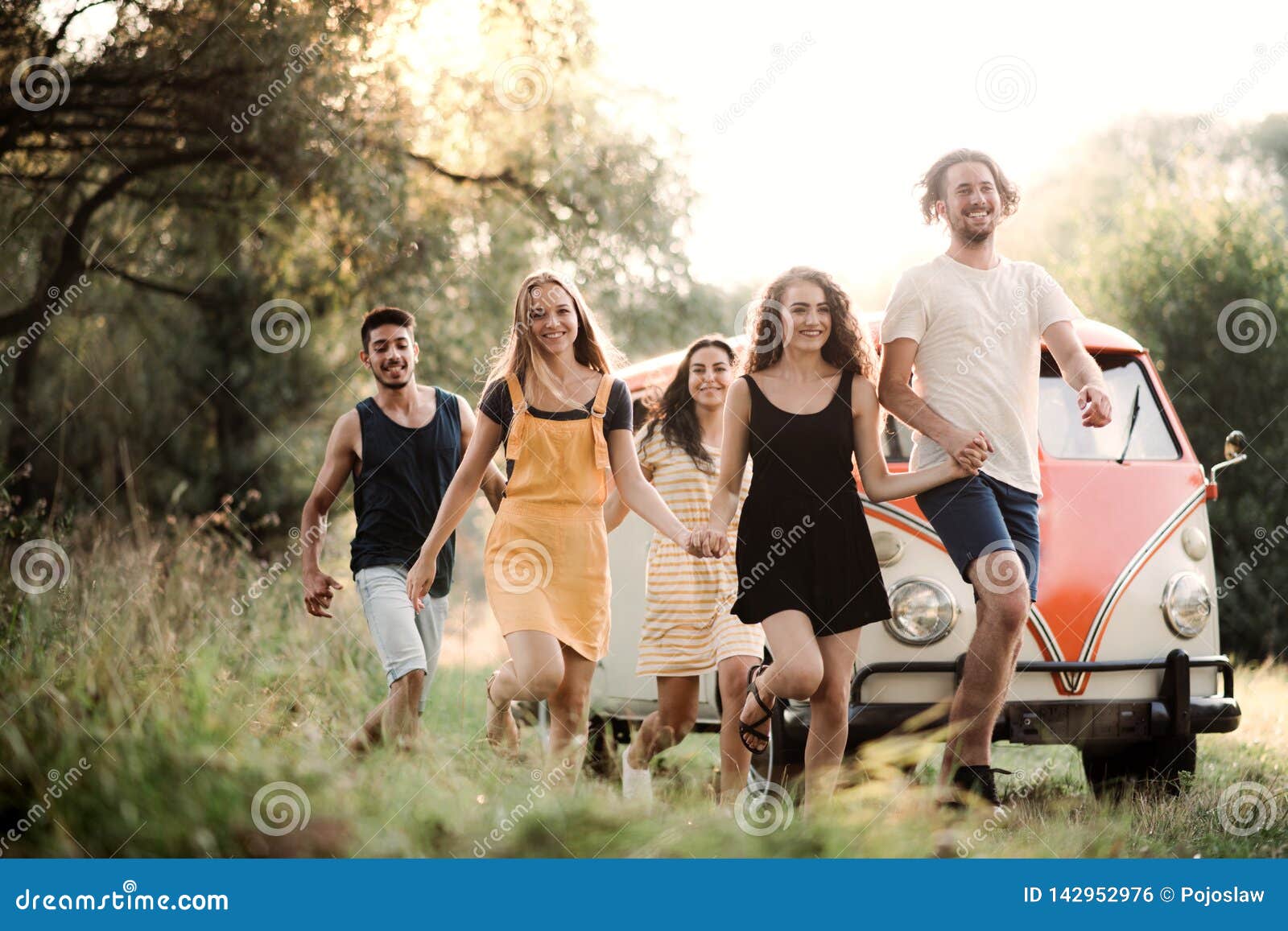 A Group of Young Friends on a Roadtrip through Countryside, Running ...